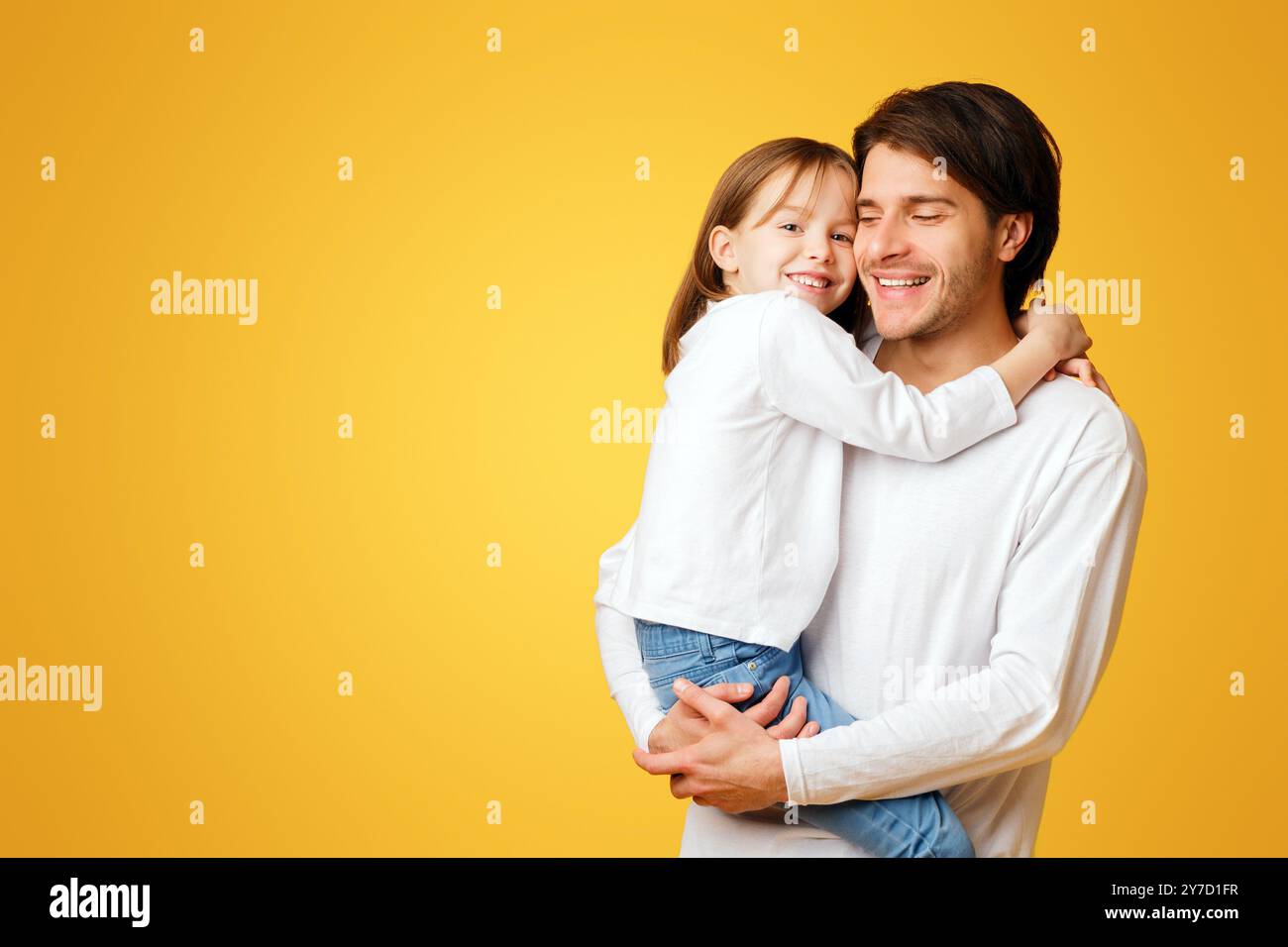 Positive father and daughter posing together on yellow background Stock ...