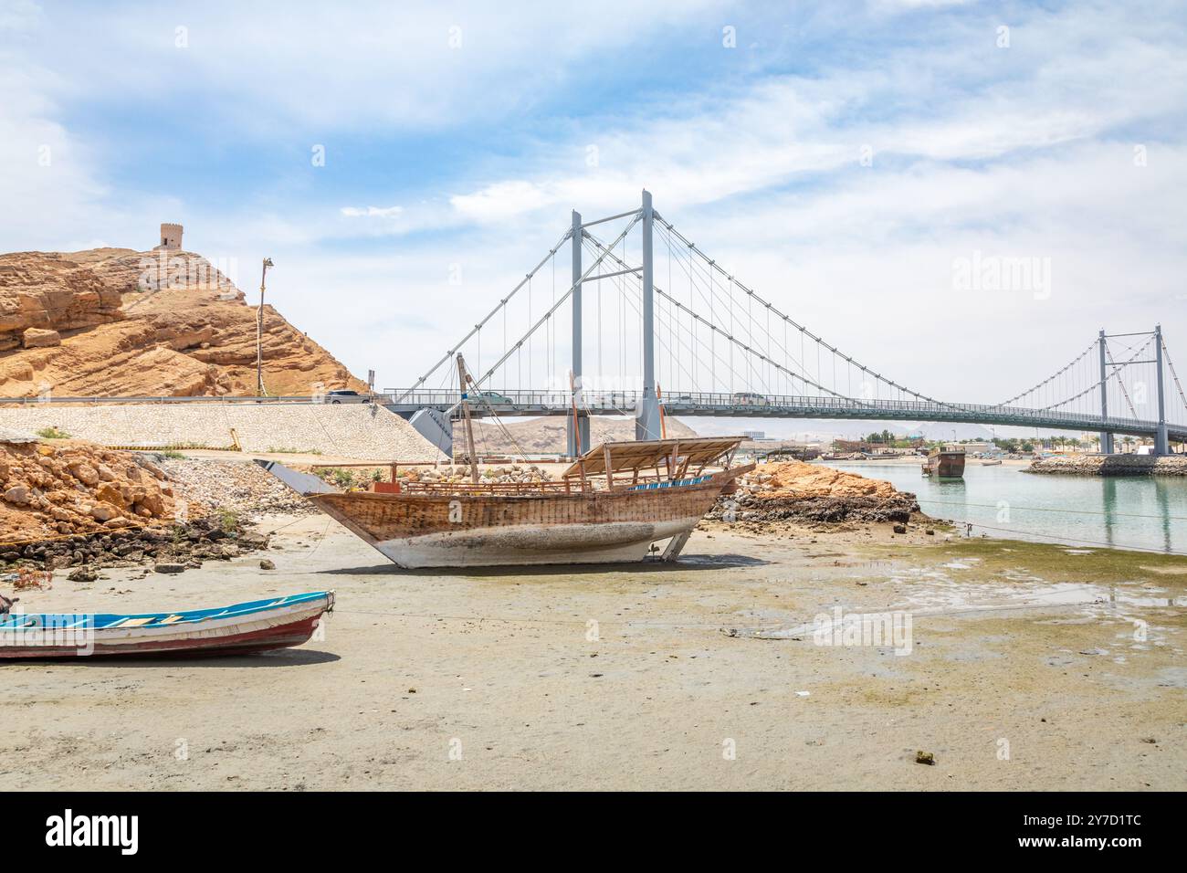 Al Ayjah bridge and traditional omani wooden dhow boats on a seashore ...