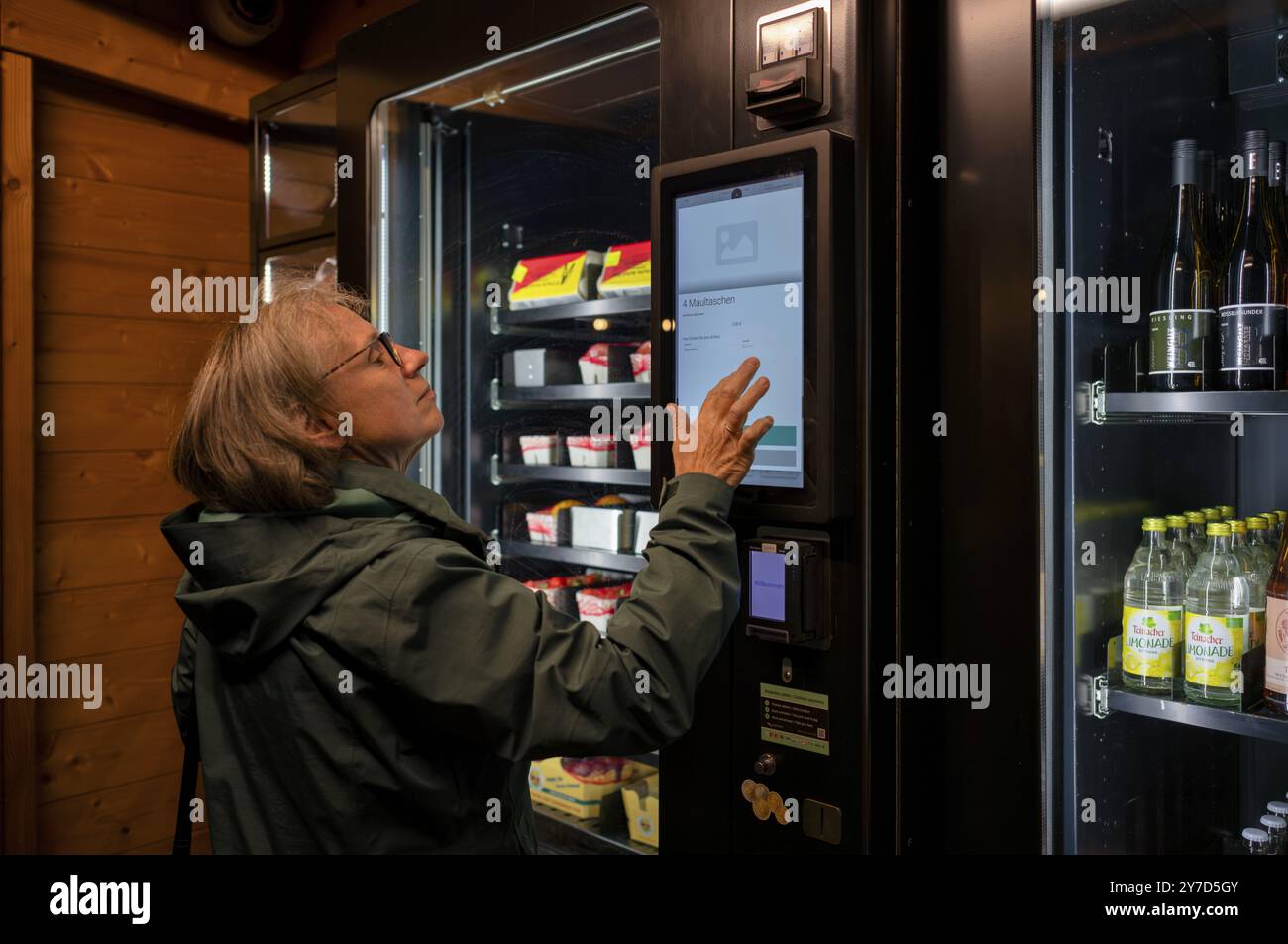 Elderly woman buying groceries at vending machine, display, food ...