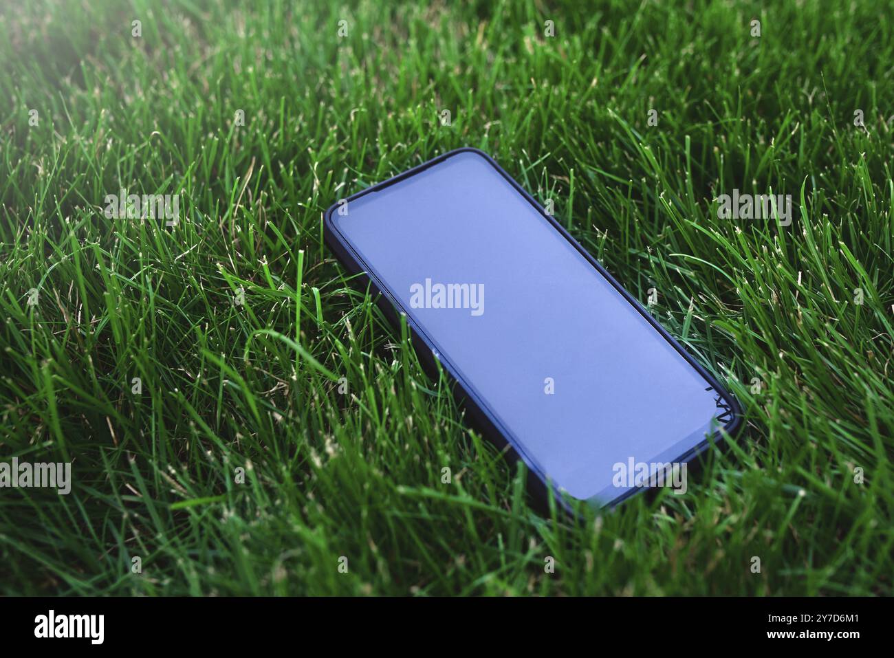 Smartphone and black screen on grass background Stock Photo - Alamy
