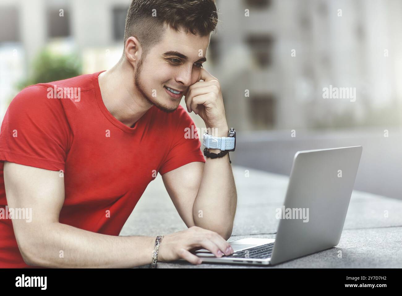 Young attractive guy who is smiling looking at his laptop screen, Young ...