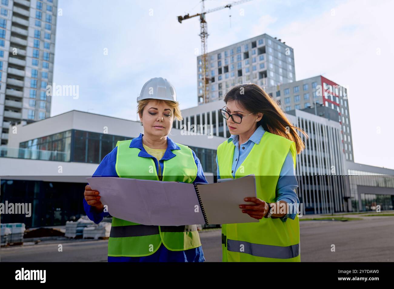 Two confident women talking working on construction of residential ...
