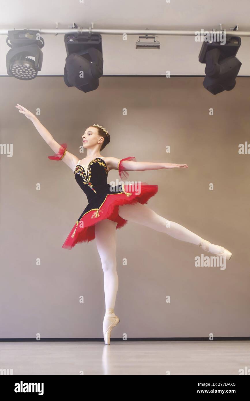 Teenager ballerina stands gracefully in pointe shoes on her toes in the ...