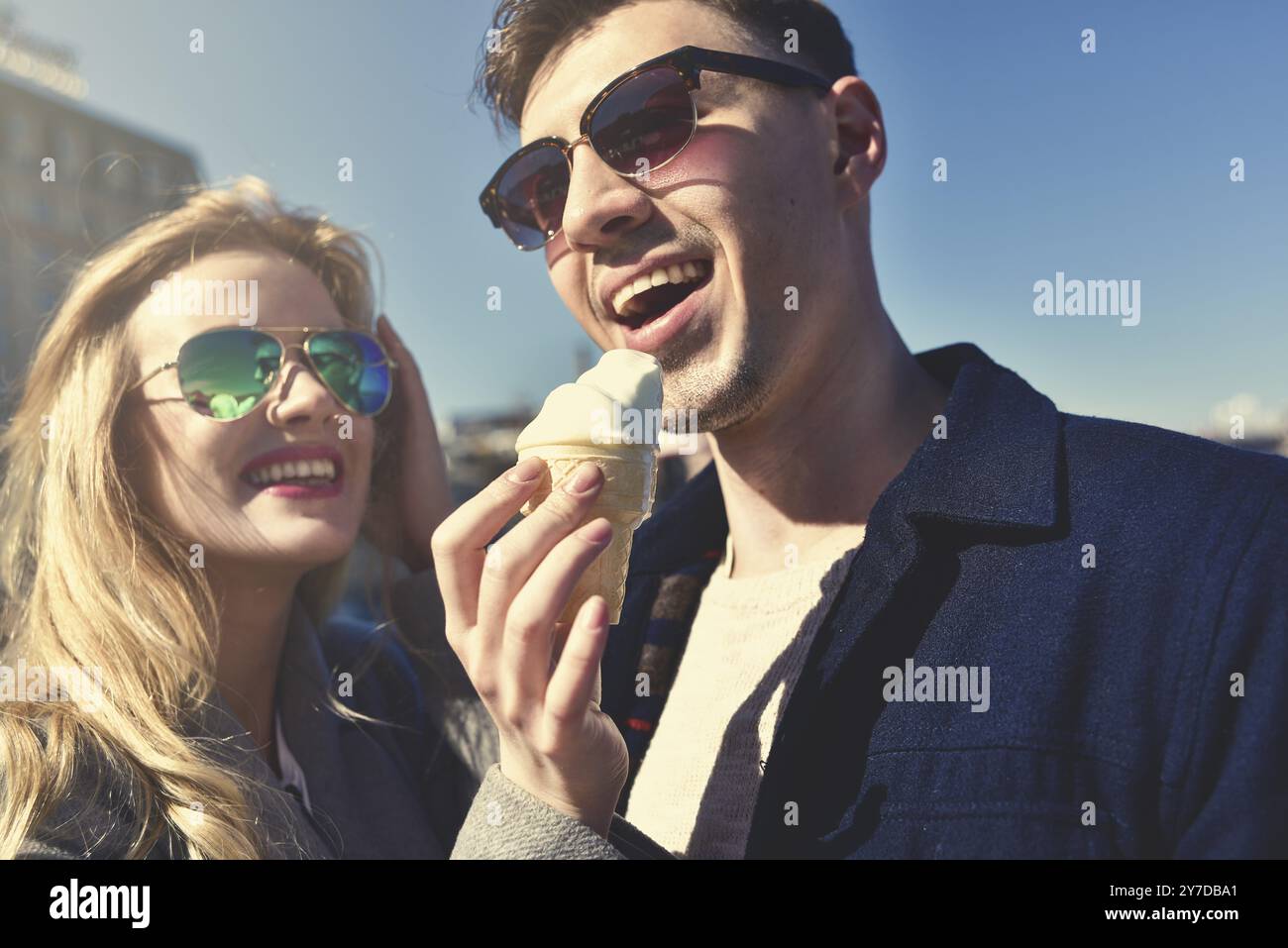 Happy romantic caucasian couple in sunglasses. Funny girl eat the ice ...