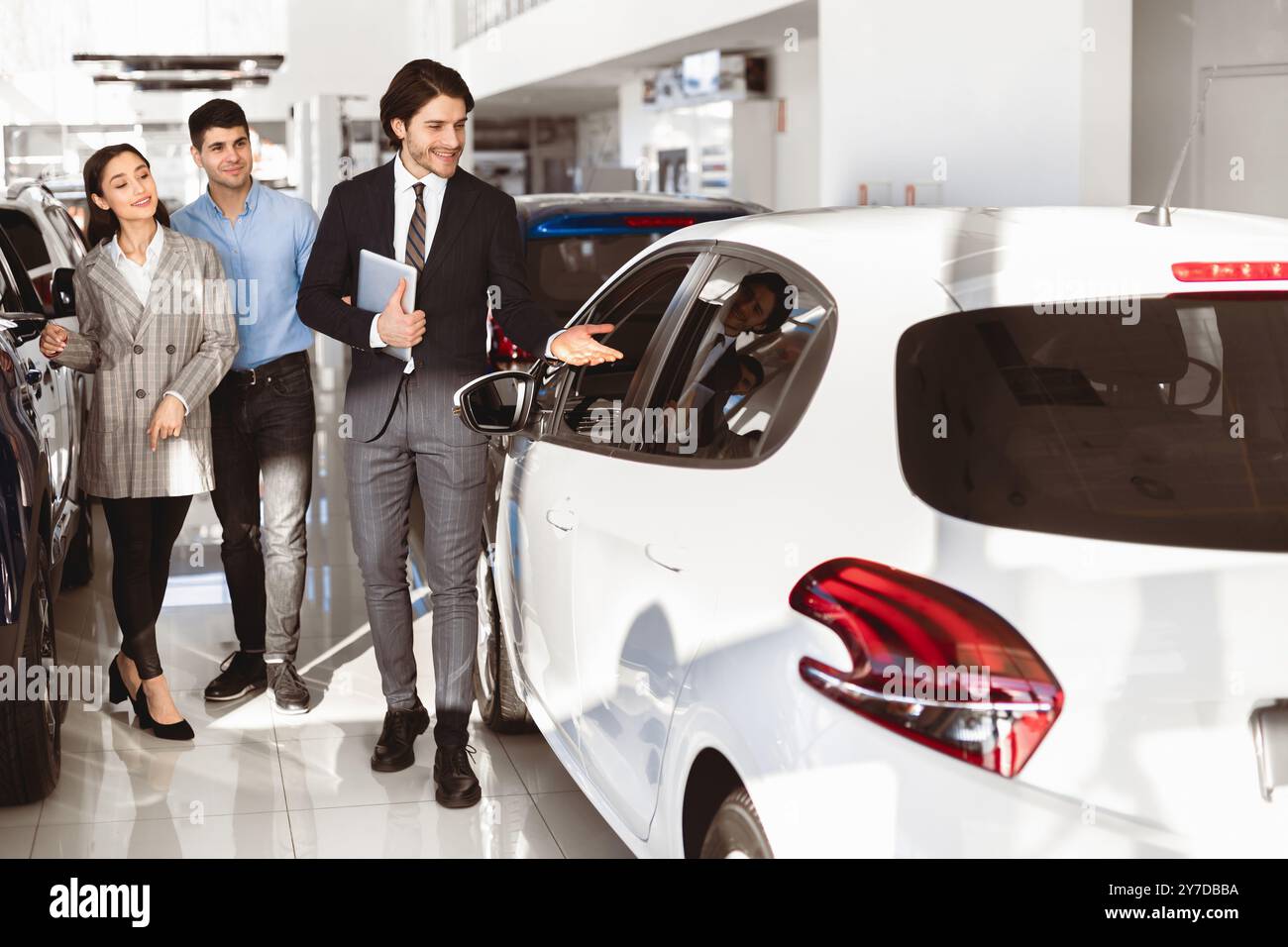 Dealer Showing Young Family New Auto In Dealership Store Stock Photo ...
