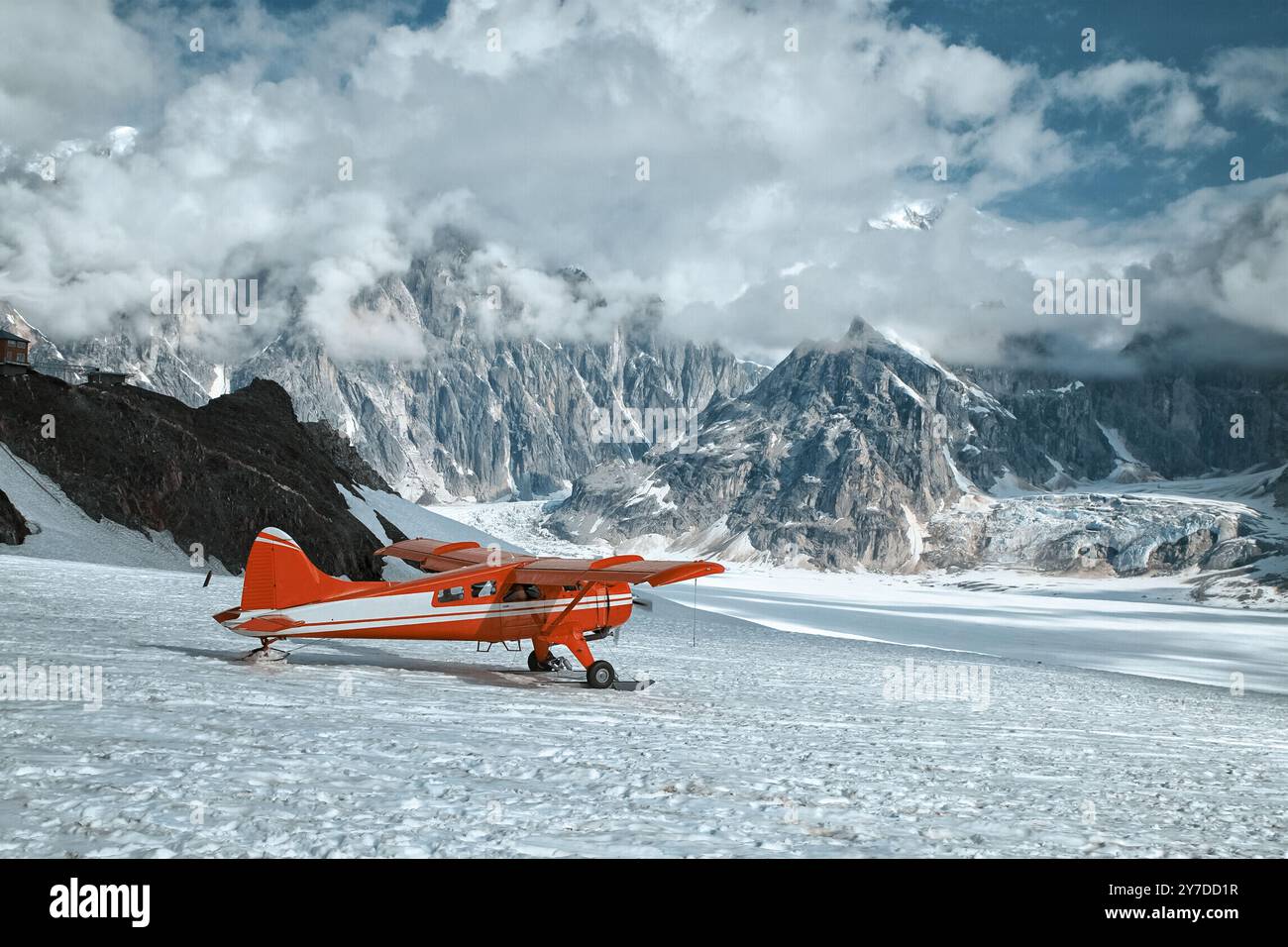 Red plane landing on a glacier in Denali mountains. Winter expedition ...