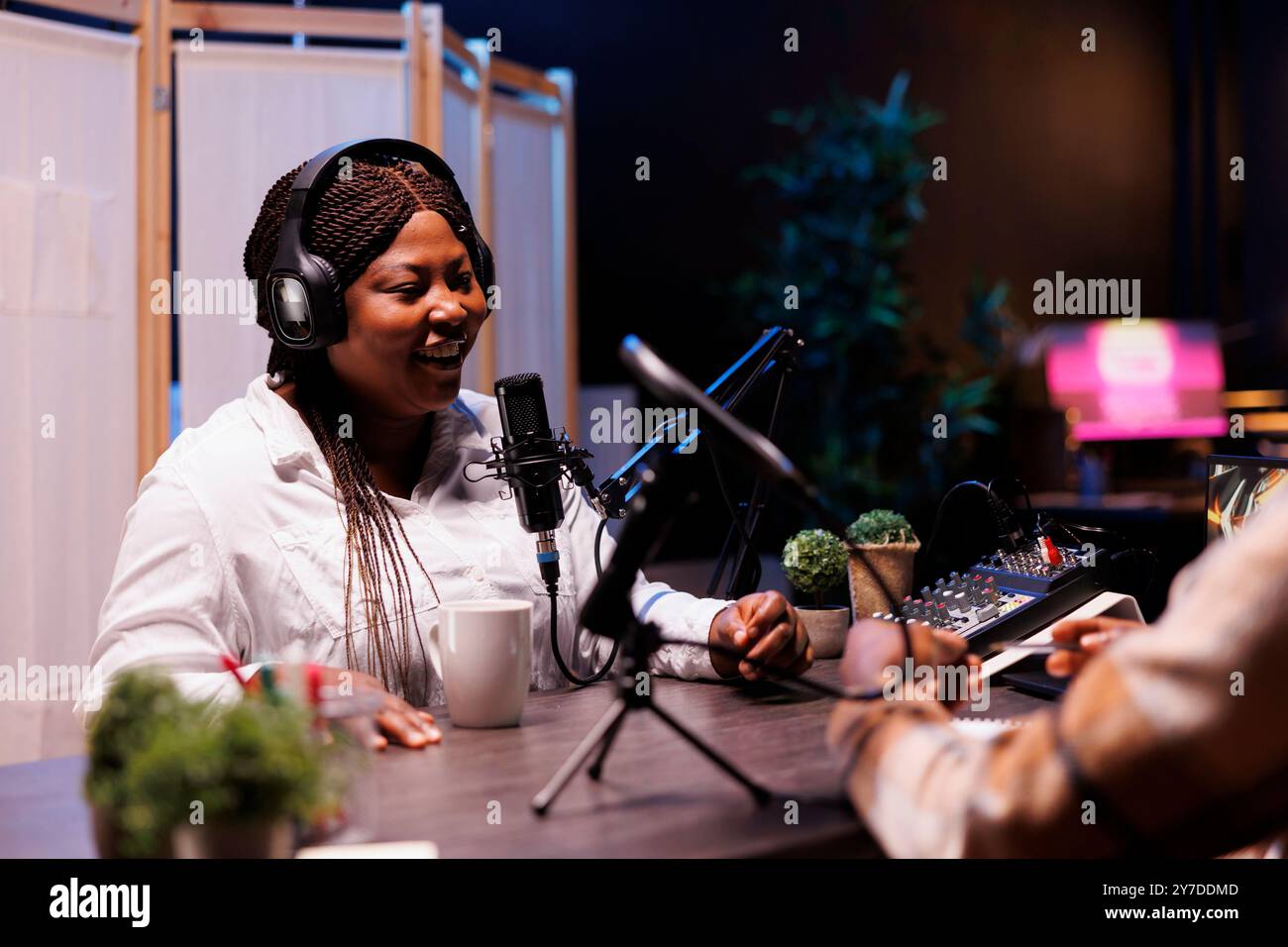 Cheerful female african american influencer speaking into microphone ...