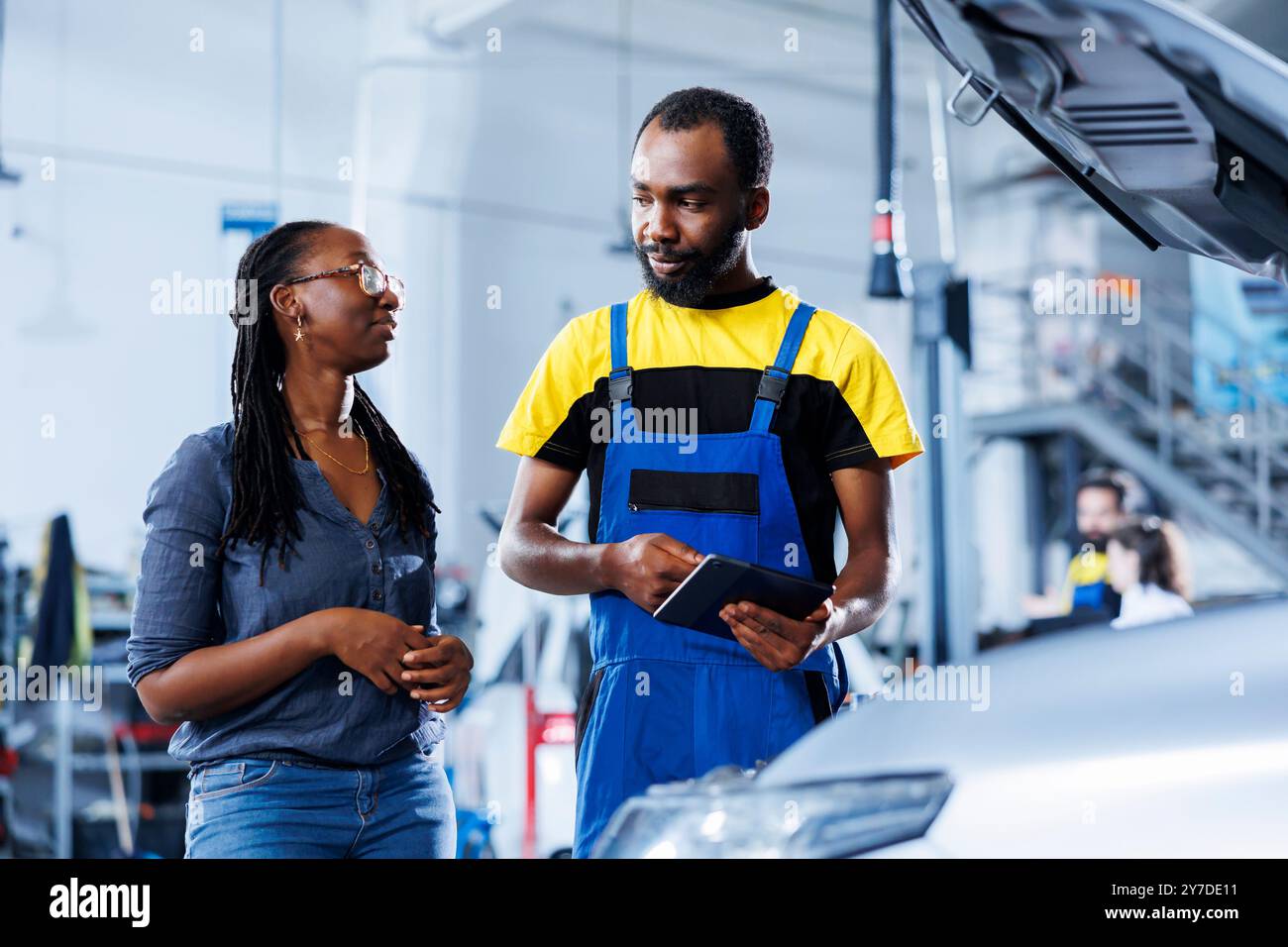 Mechanic at auto repair shop conducts annual vehicle checkup, informing ...