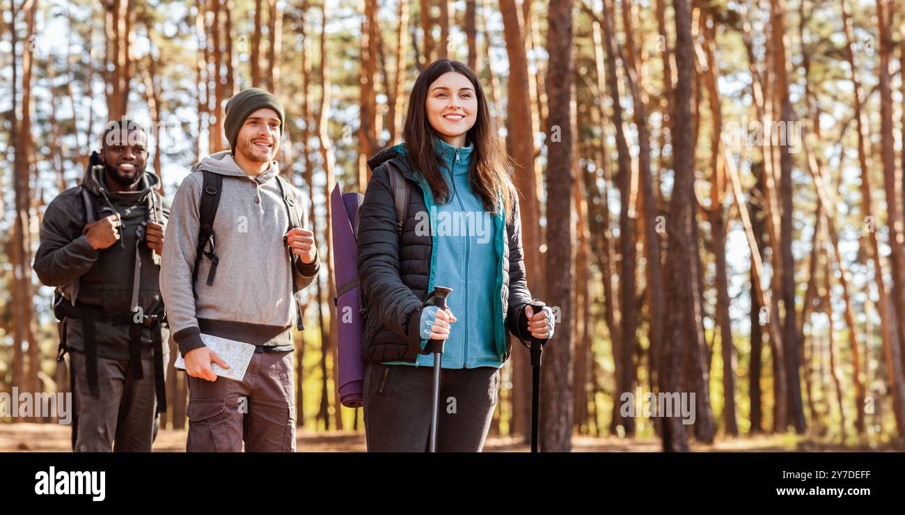 Smiling hikers looking at camera over pine forest background Stock ...