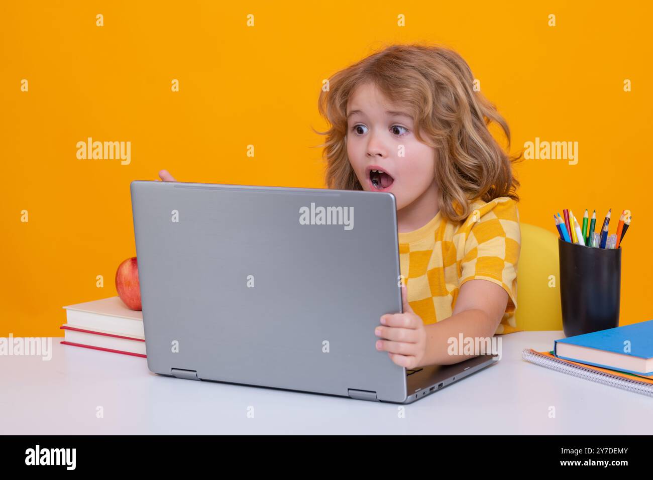 Excited school child using laptop computer. School child studying in ...