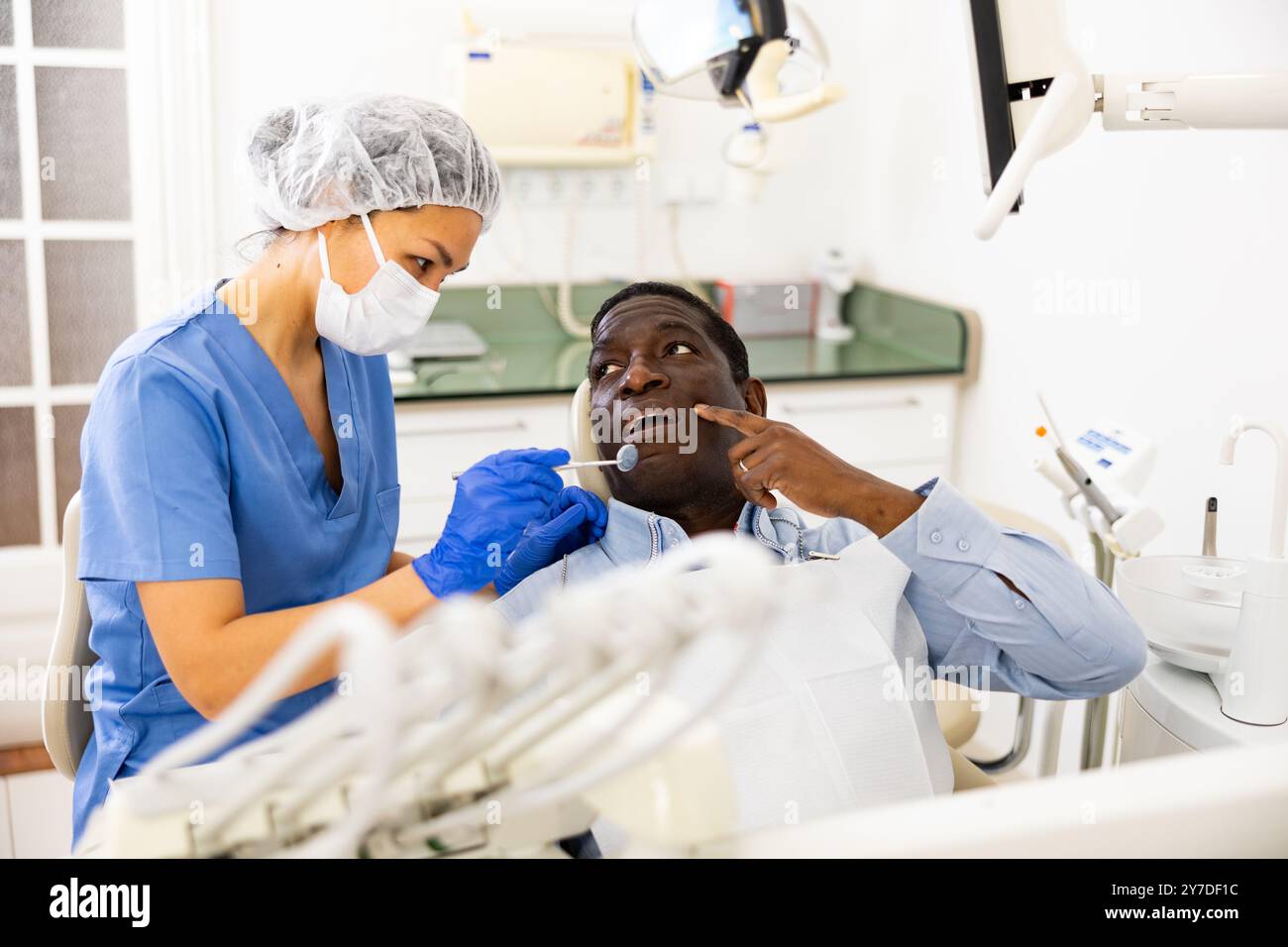 Patient pointing at tooth with problem during consultation in dental ...