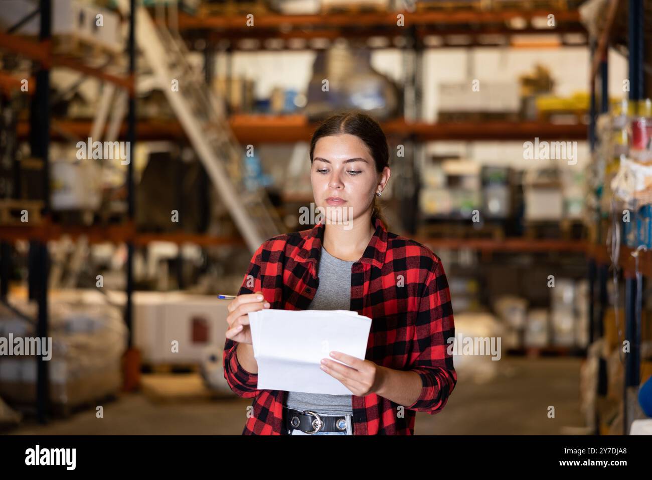 Woman checking availability order list in storage warehouse Stock Photo ...