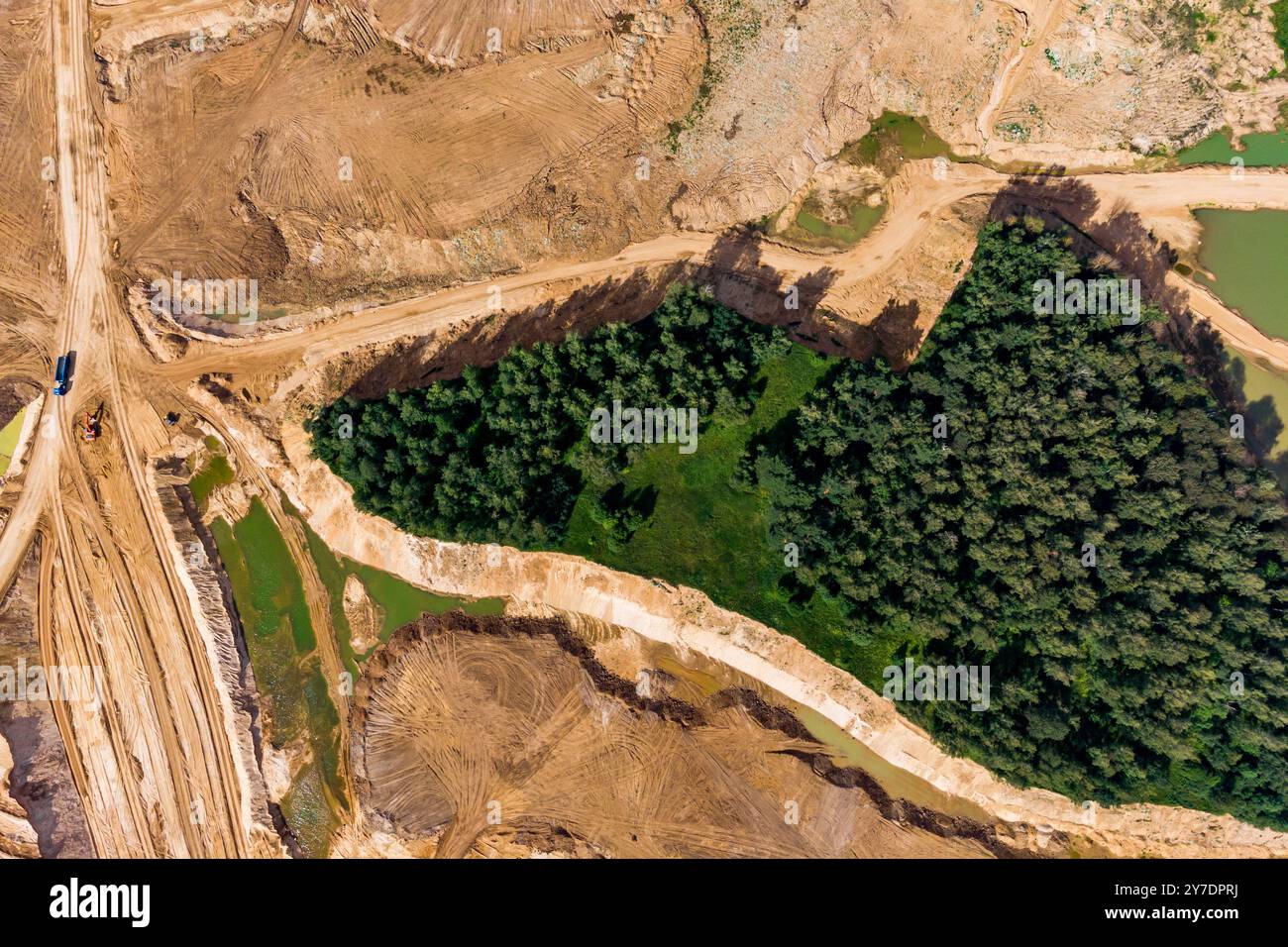 Aerial view of a preserved forest area in the middle of a huge sand ...