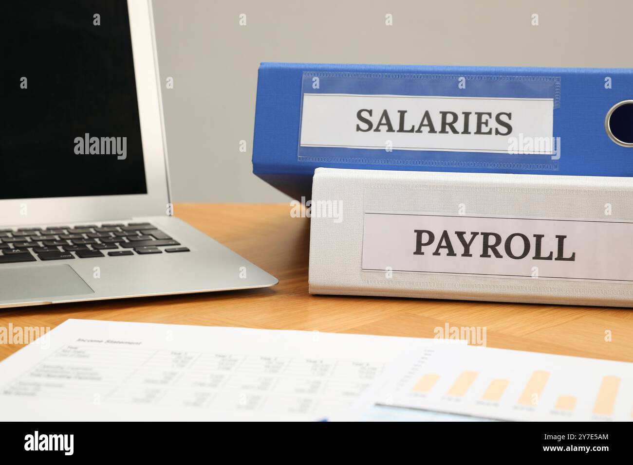 Payroll. Folders, charts and laptop on wooden table, closeup Stock ...