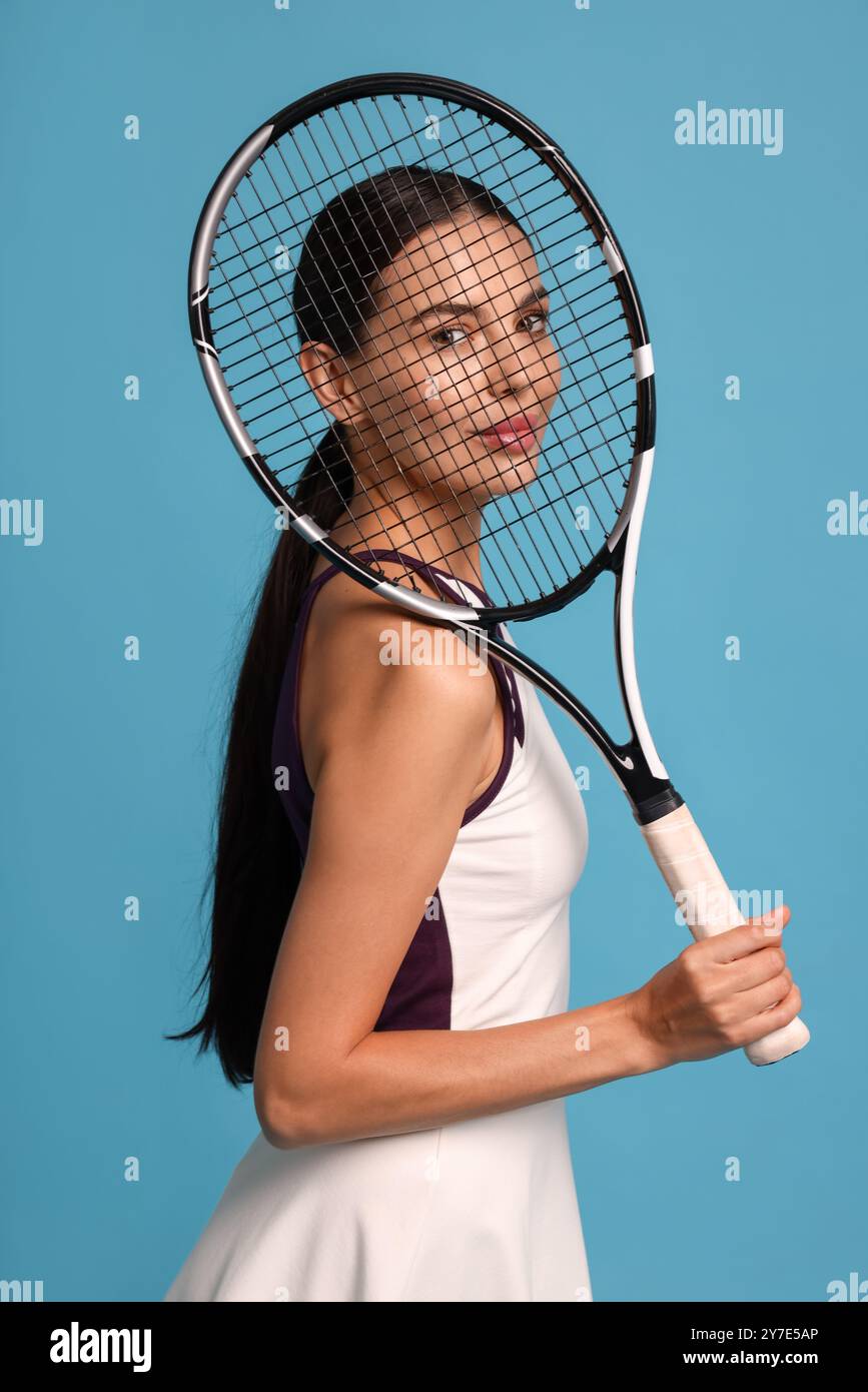 Beautiful young woman with tennis racket on light blue background Stock ...