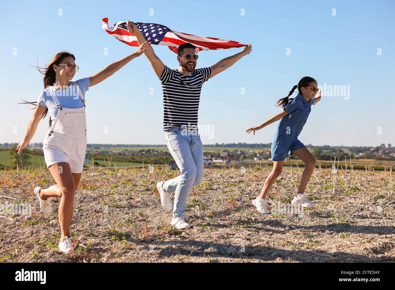 Happy family running with flag of USA outdoors Stock Photo - Alamy