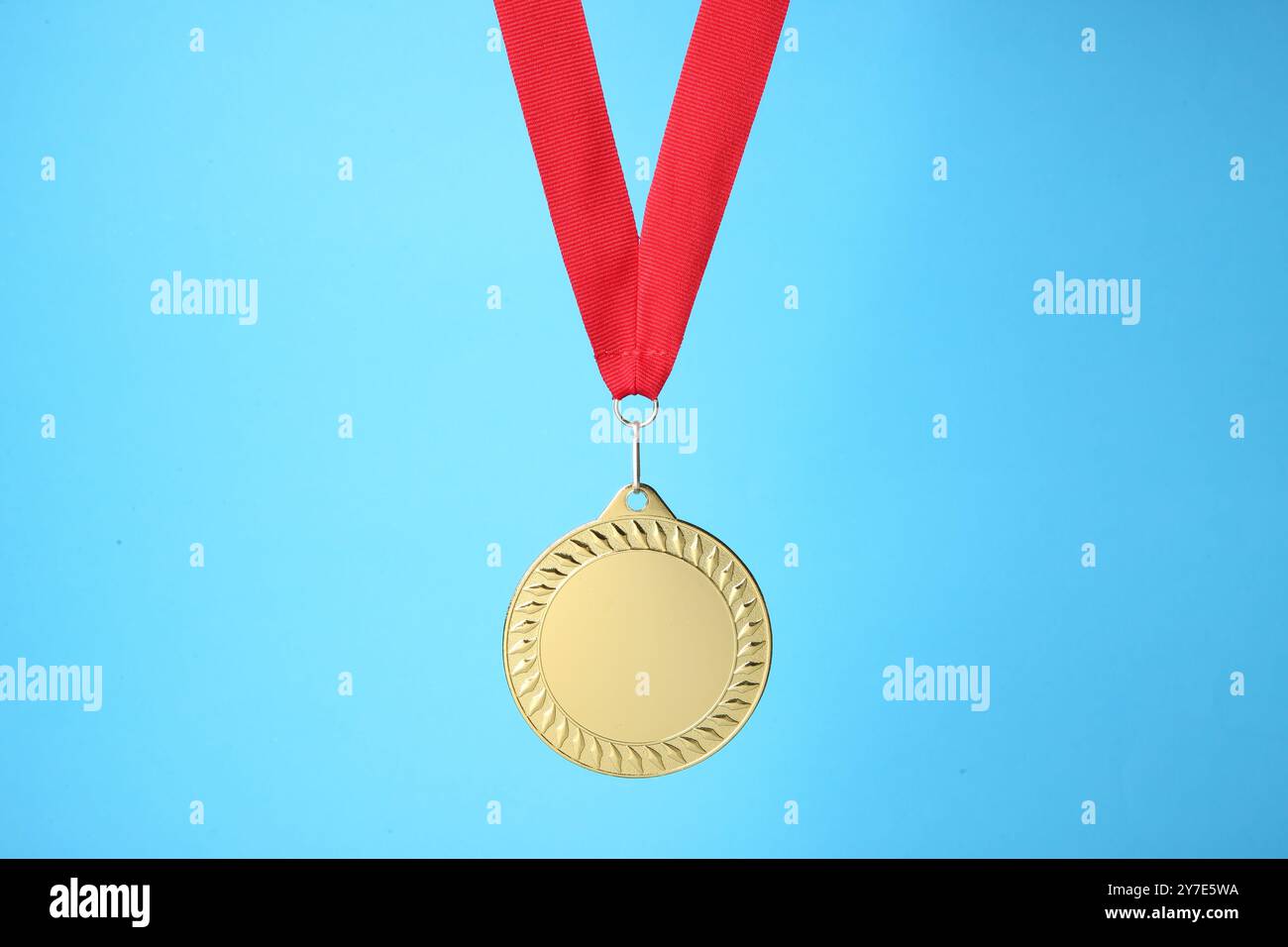 One golden medal with ribbon on light blue background Stock Photo - Alamy