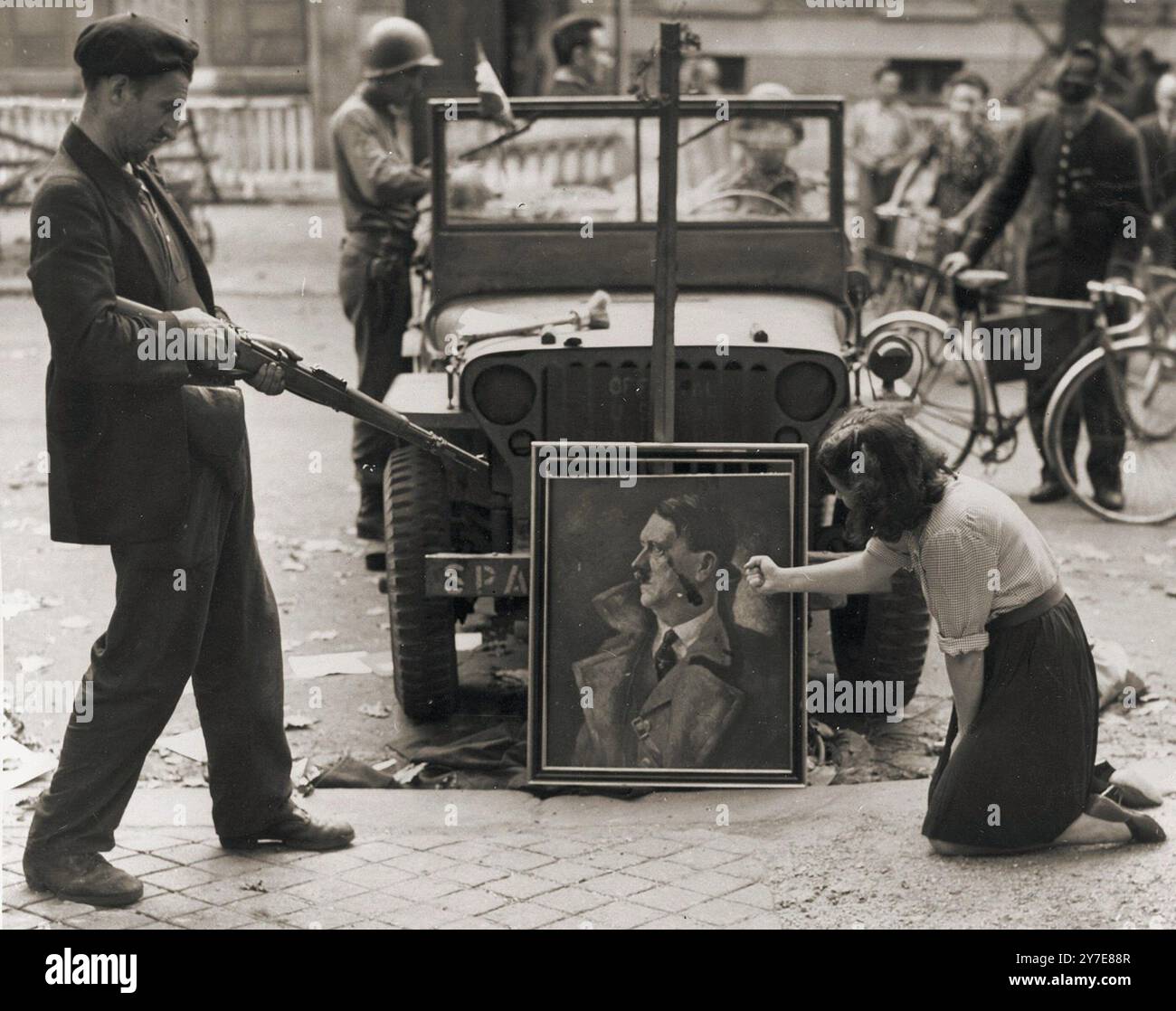 A French civilian and a French resistance fighter deface a portrait of ...