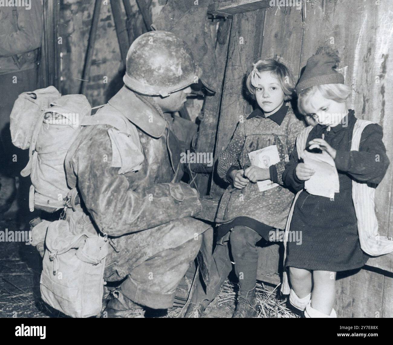 An American soldier talking o two french girls. They are holding ...