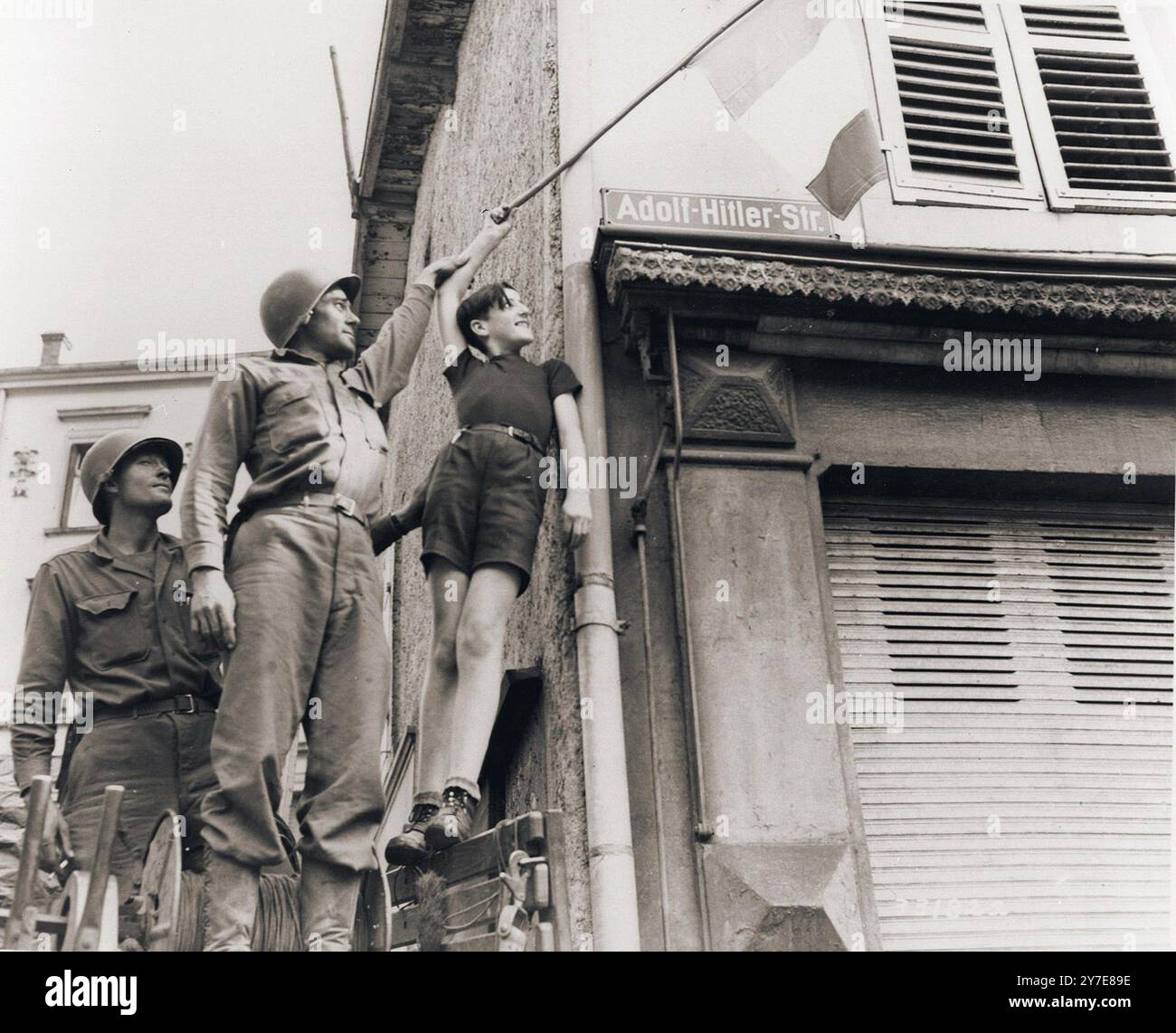 wo US soldiers help a French boy affix the Tricolor above a Hitler ...