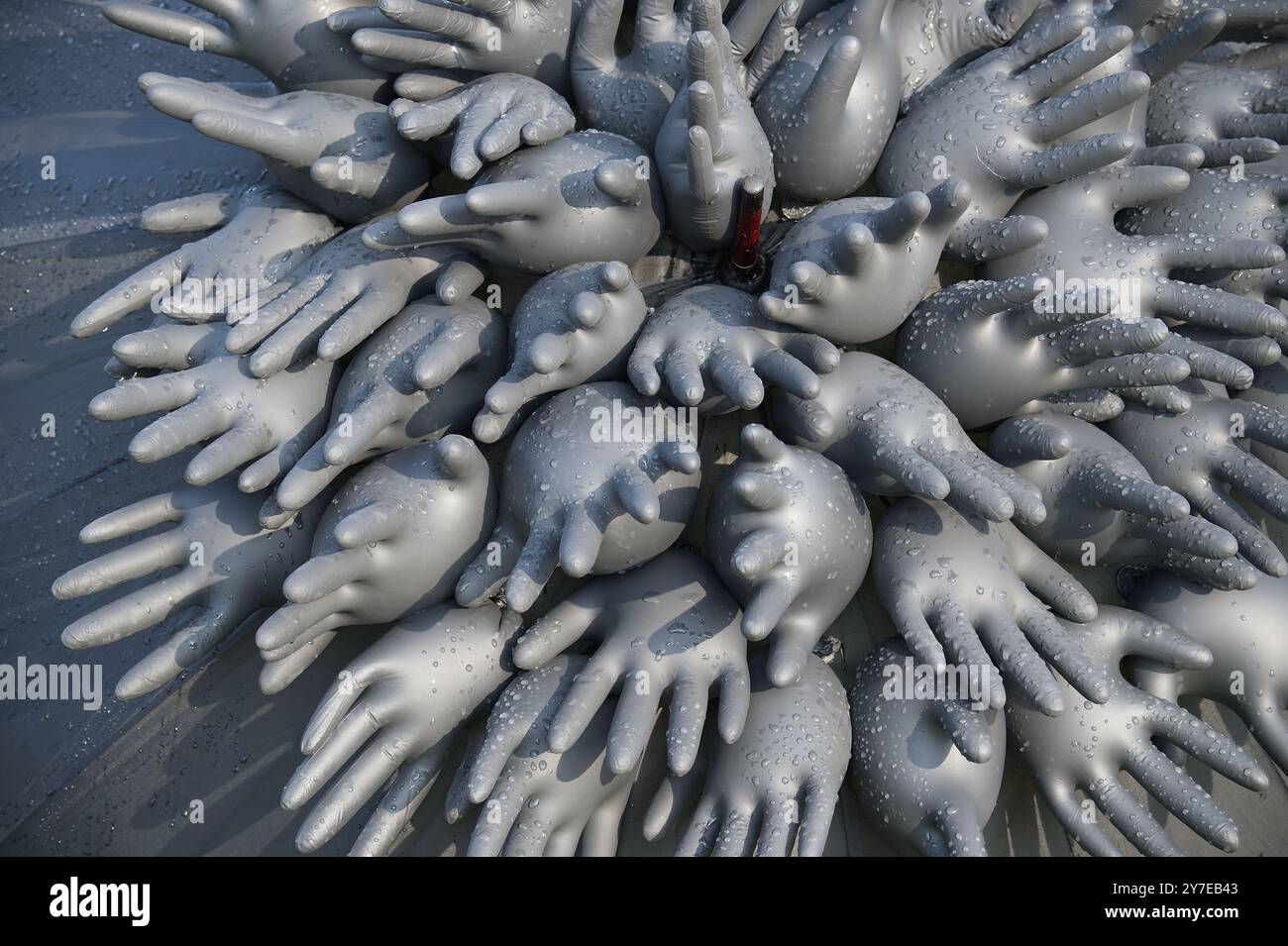 Inflated rubber gloves covered in water droplets forms an abstract ...