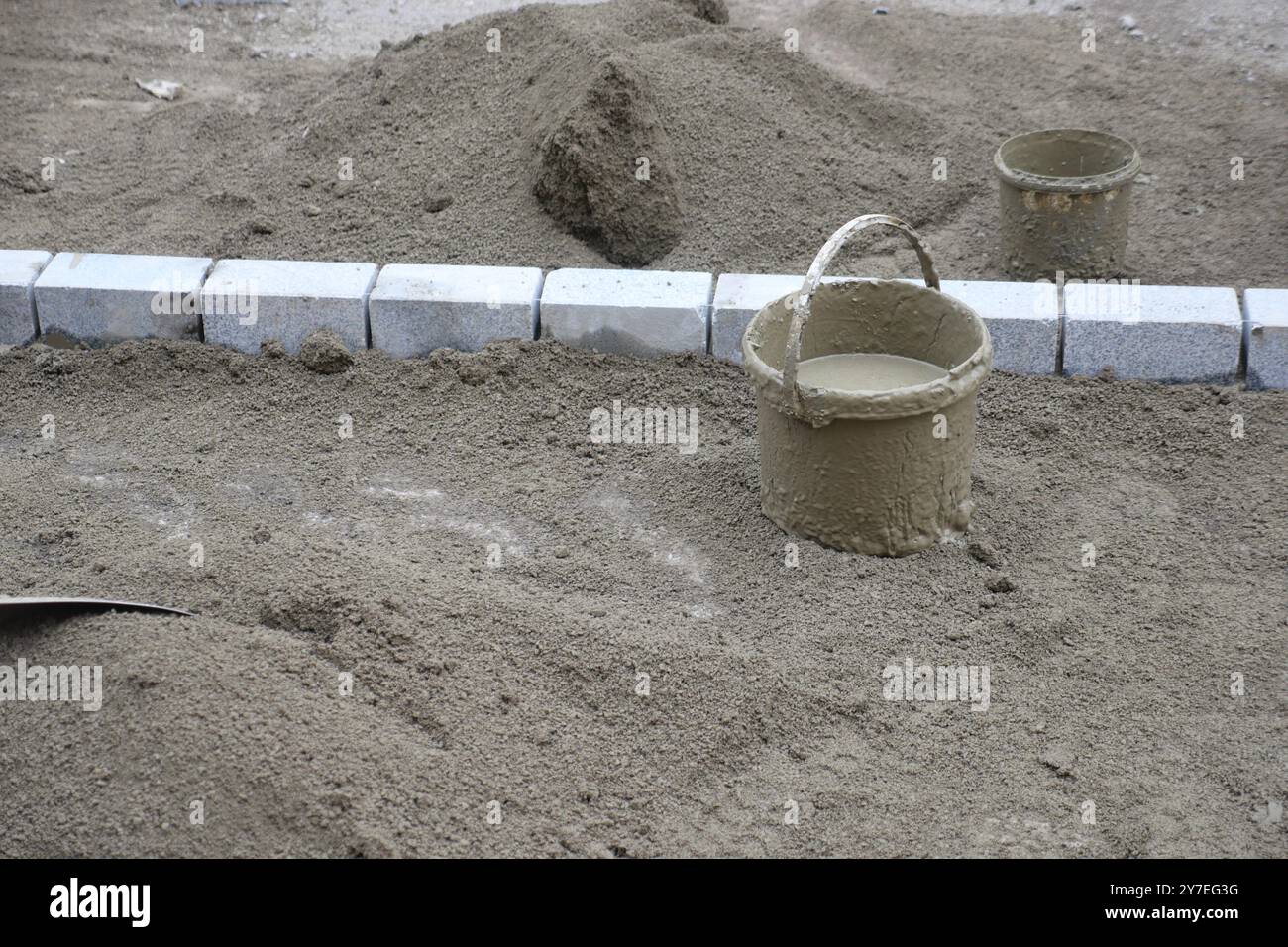 A construction site where sand and buckets are used to prepare for ...