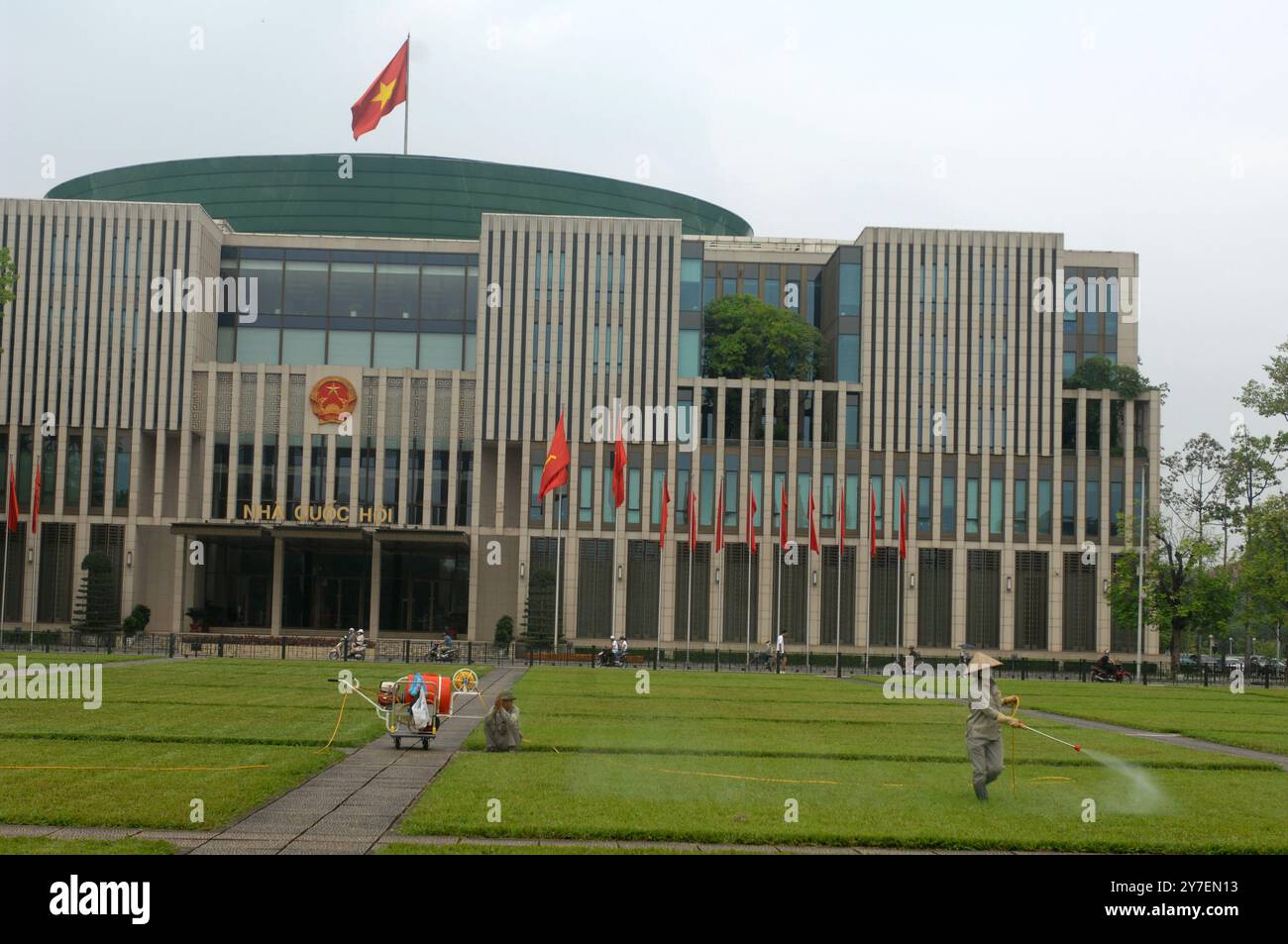 Female gardeners maintaining the lawns outside the Viet Nam National Assembly Building, Hanoi ...