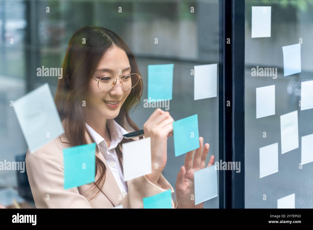Happy young business woman working on her project at the office and ...