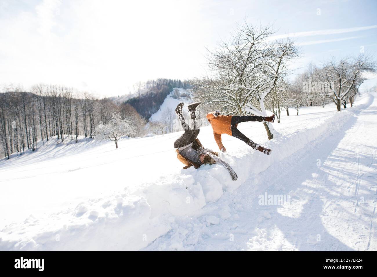 Friends having fun, jumping into high snow. First snowfall of the ...