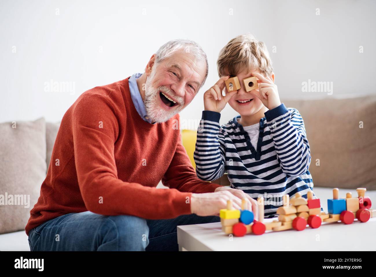 Boy and grandpa playing with wooden blocks. Grandfather spending time ...
