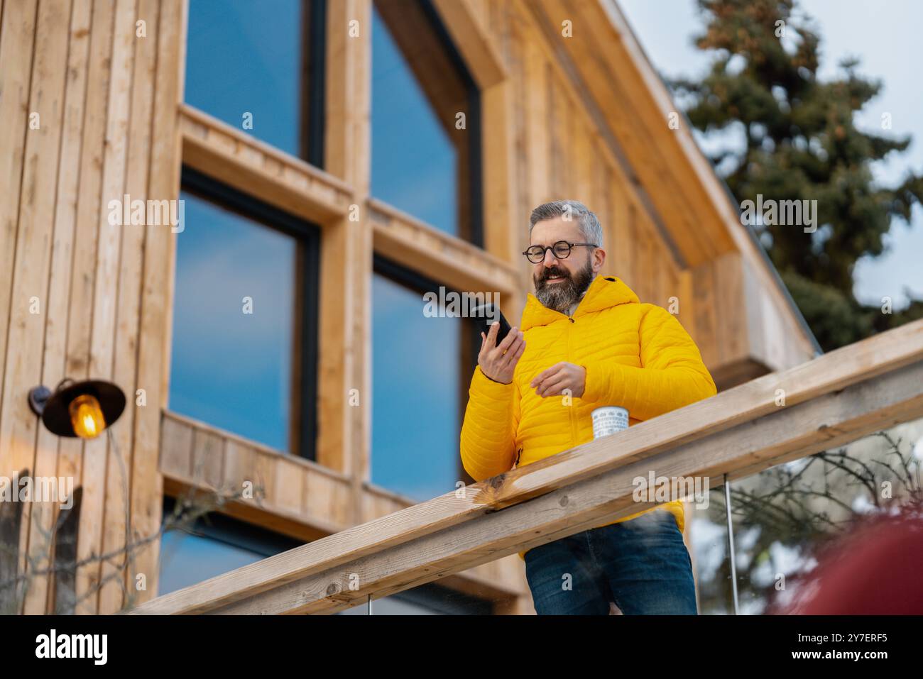 Man working from cozy cabin in mountains, making call with client ...