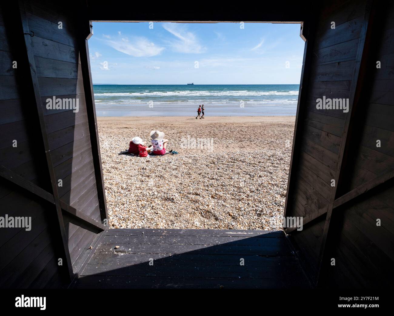 A typical beach scene viewed from inside a beach changing hut, Weymouth ...