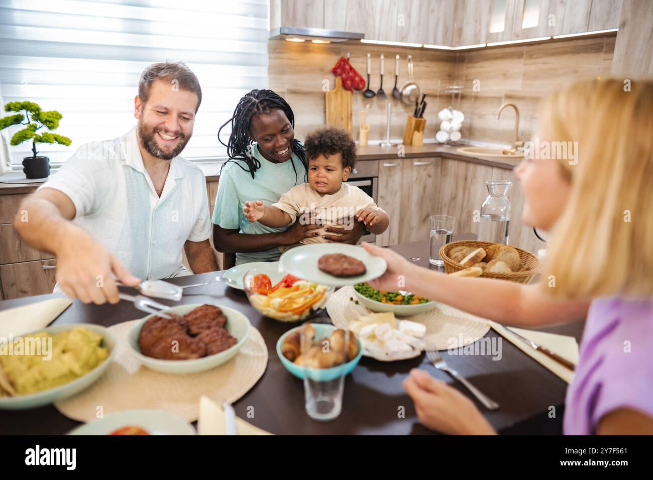 Friendly family sitting table hi-res stock photography and images - Alamy
