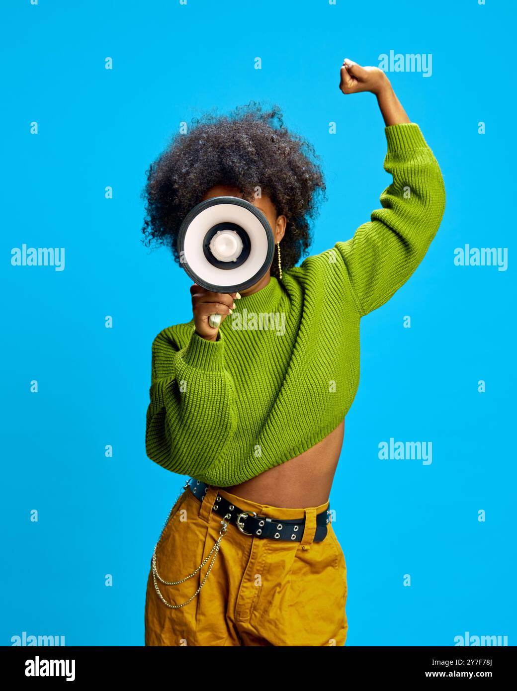 Bold woman raises her arm in power while holding megaphone. Dressed in ...