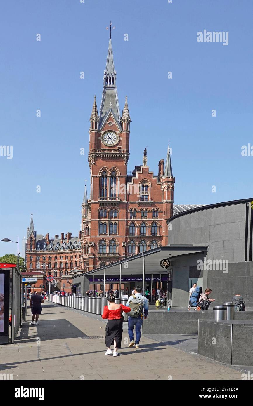 Couple strolling pavement entrance to Kings Cross underground train ...