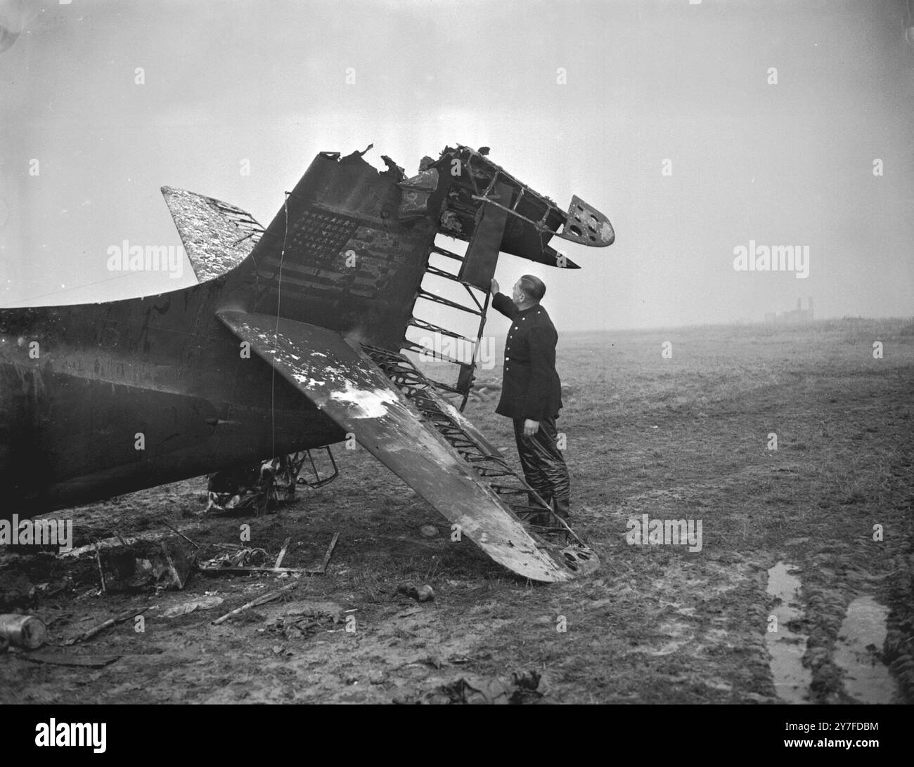 A fireman inspects the tail of the burned and wrecked aircraft of the ...