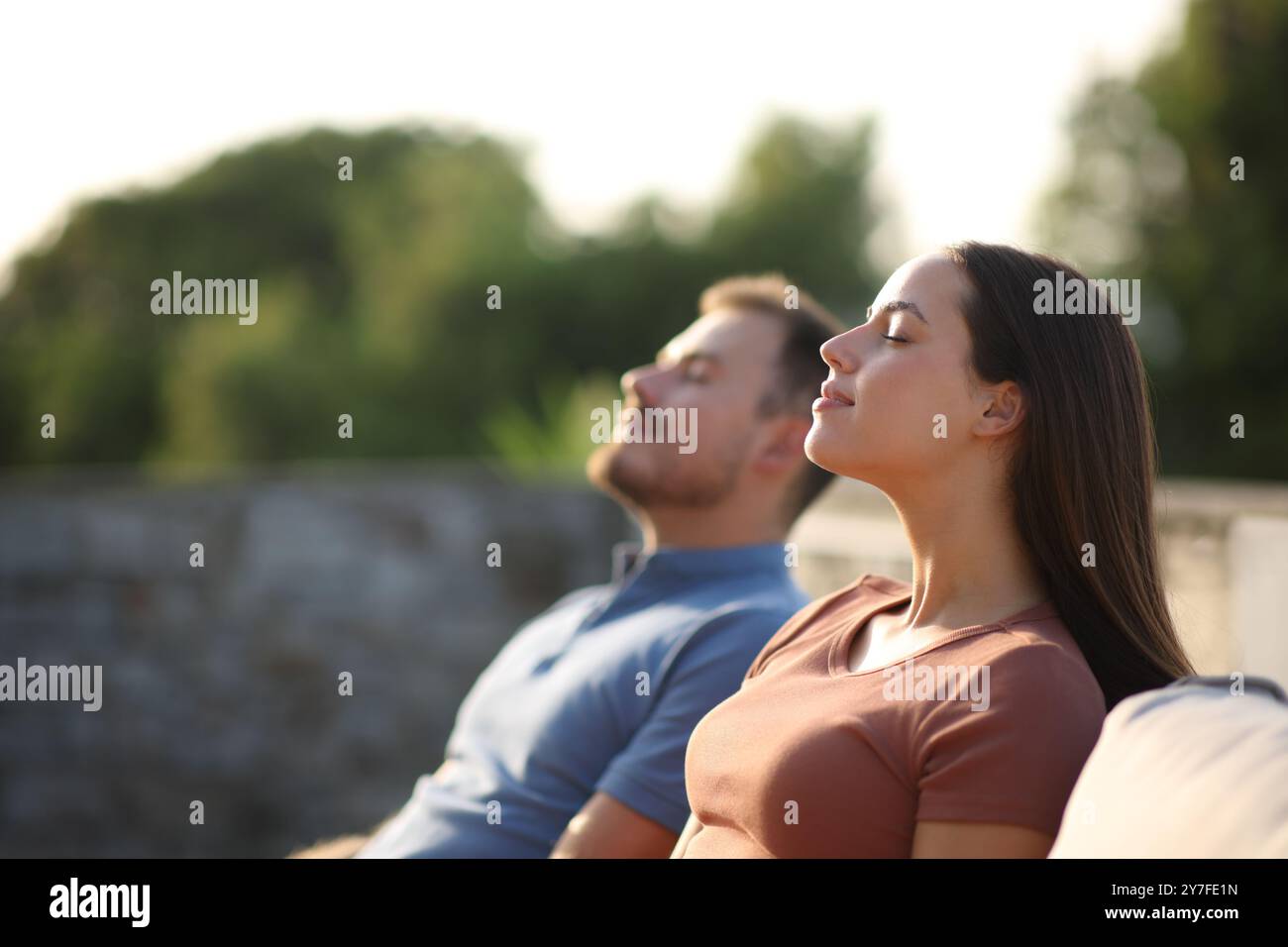 Relaxed couple breathing fresh air sitting in a couch in a terrace ...