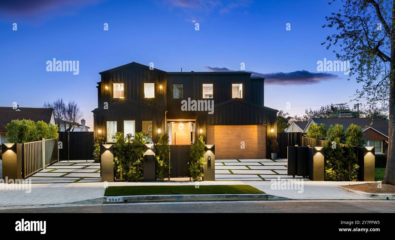 Modern two-story house with a beautiful facade and well-lit exterior in ...