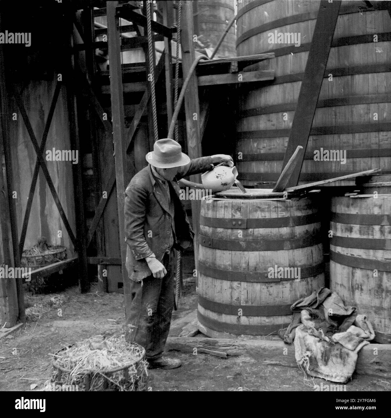 An example of primitive manufacturing methods in the 1930s, a man pours ...