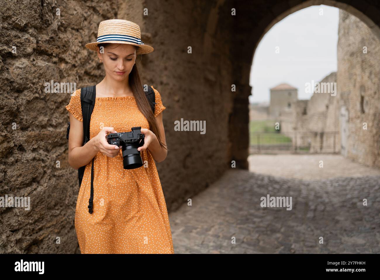 Woman tourist with camera visiting ancient castle taking pictures of ...