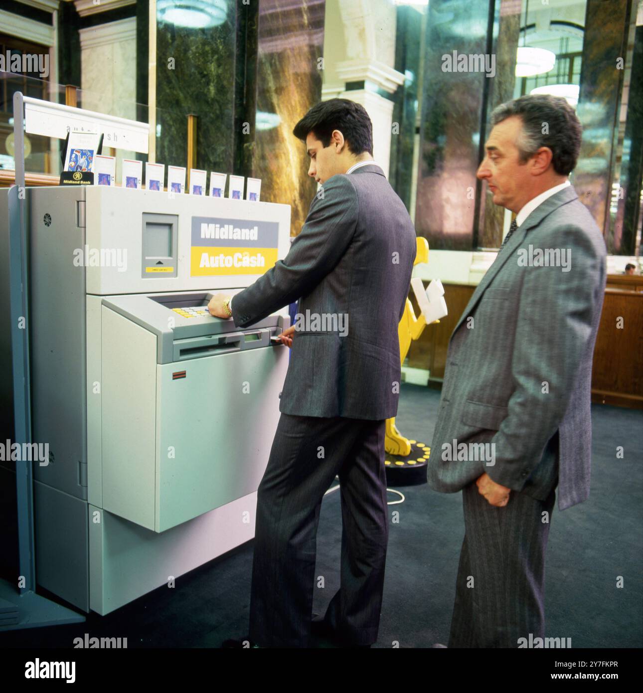Midland Bank : Men queuing to use the automatic cash dispenser inside the branch Stock Photo - Alamy