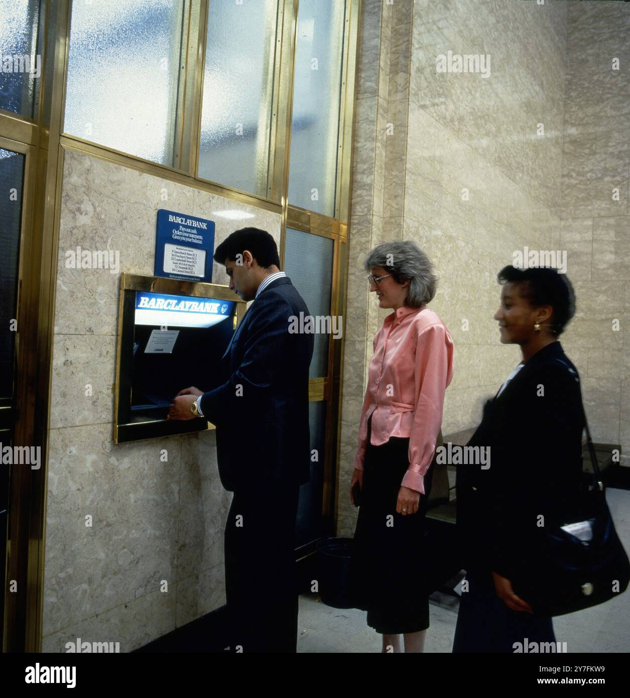 Barclays Bank : People queuing to use the automatic cash dispenser ...