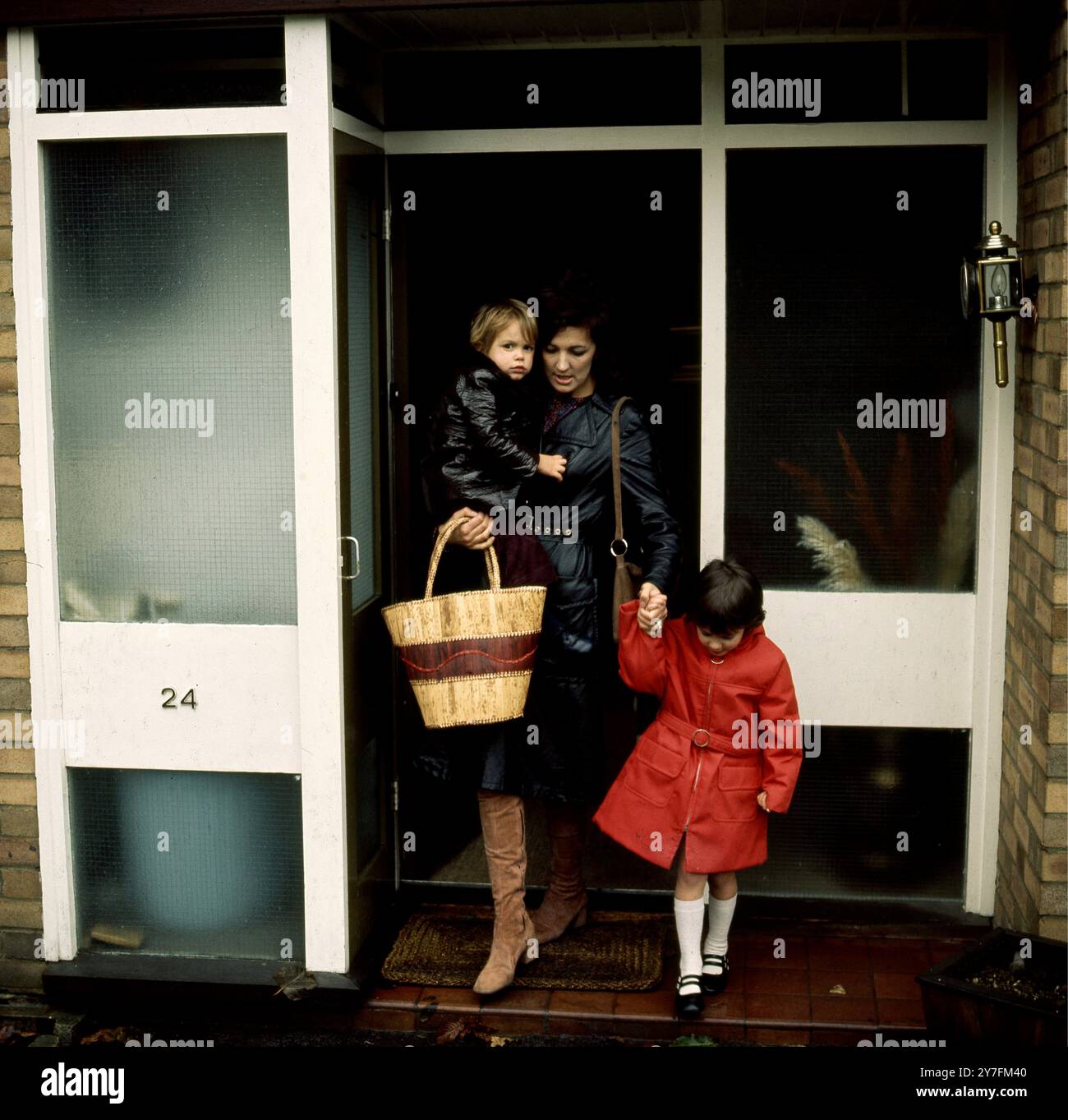 Mother and children going out on a rainy day 1970's Stock Photo - Alamy