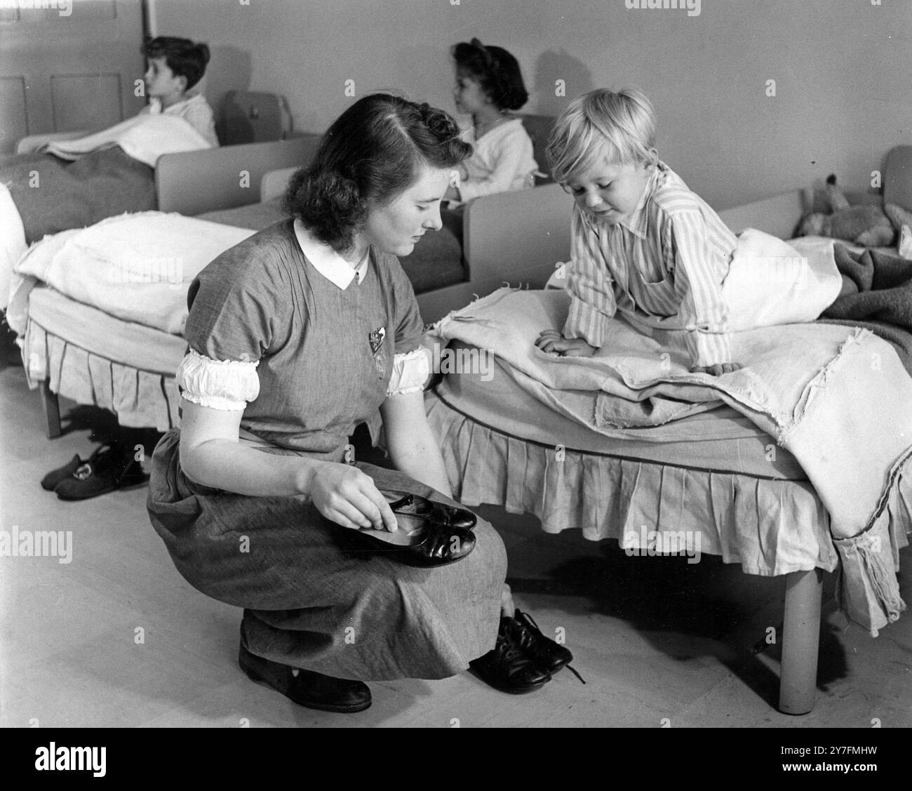 A nanny putting a young guest to bed at The Panda Hotel for Children in ...