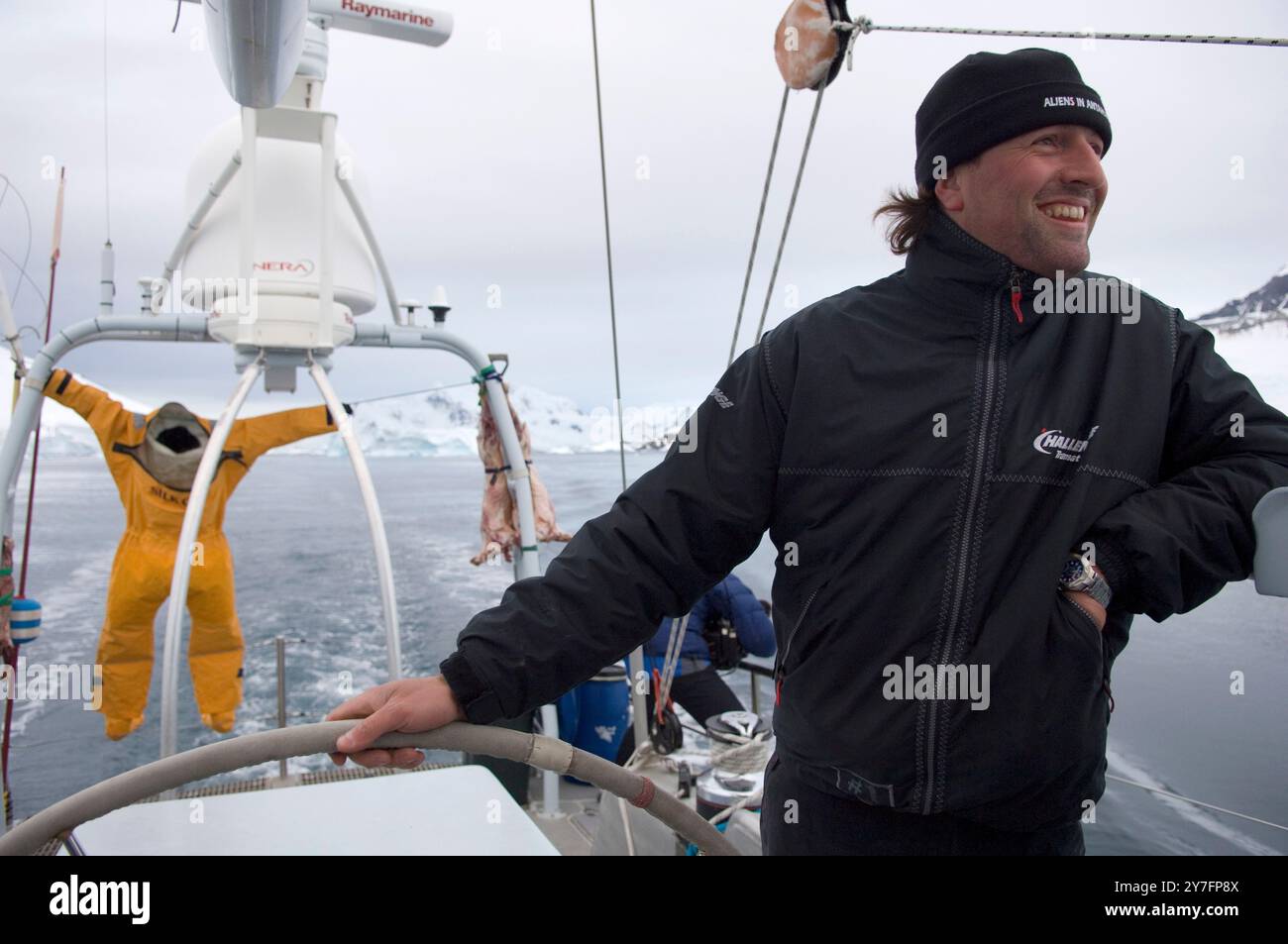 A man steers a sail boat through the waters of Paradise bay in the west coast of Antarctica's ...