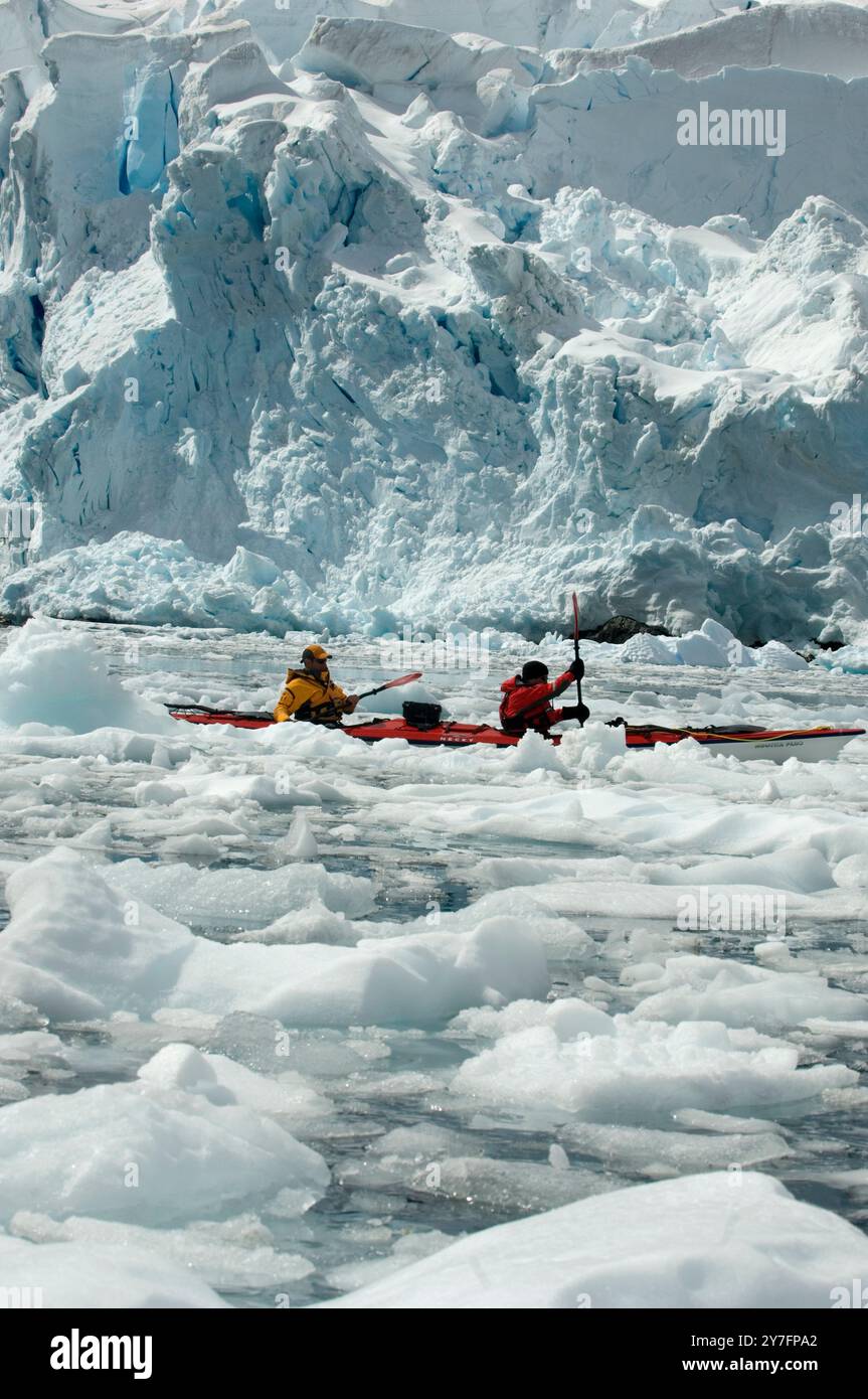 Two kayakers paddle through the ice filled waters of the Lemaire Chanel ...