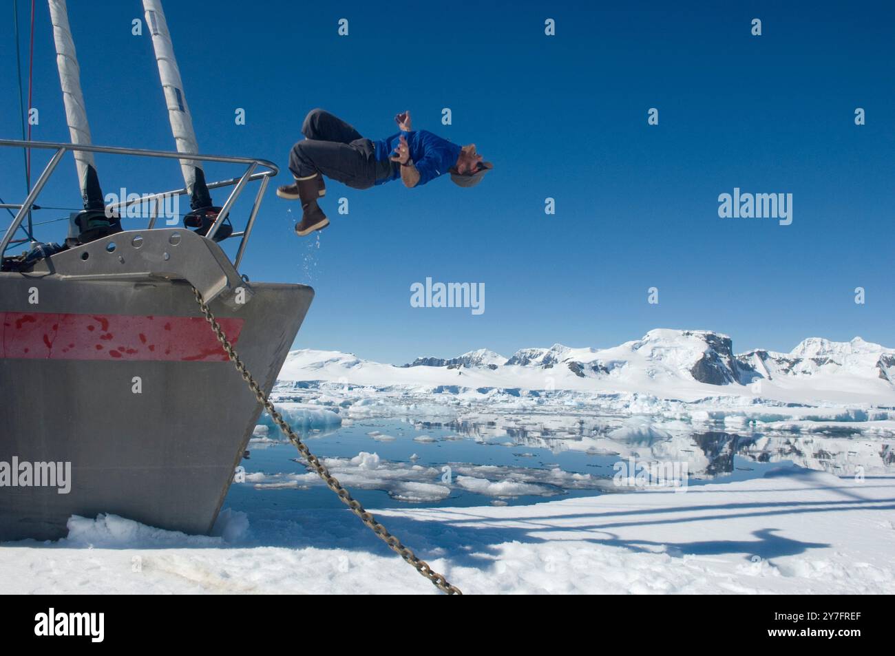 A man does a flip off of the bow of a boat onto an ice sheet in the ...