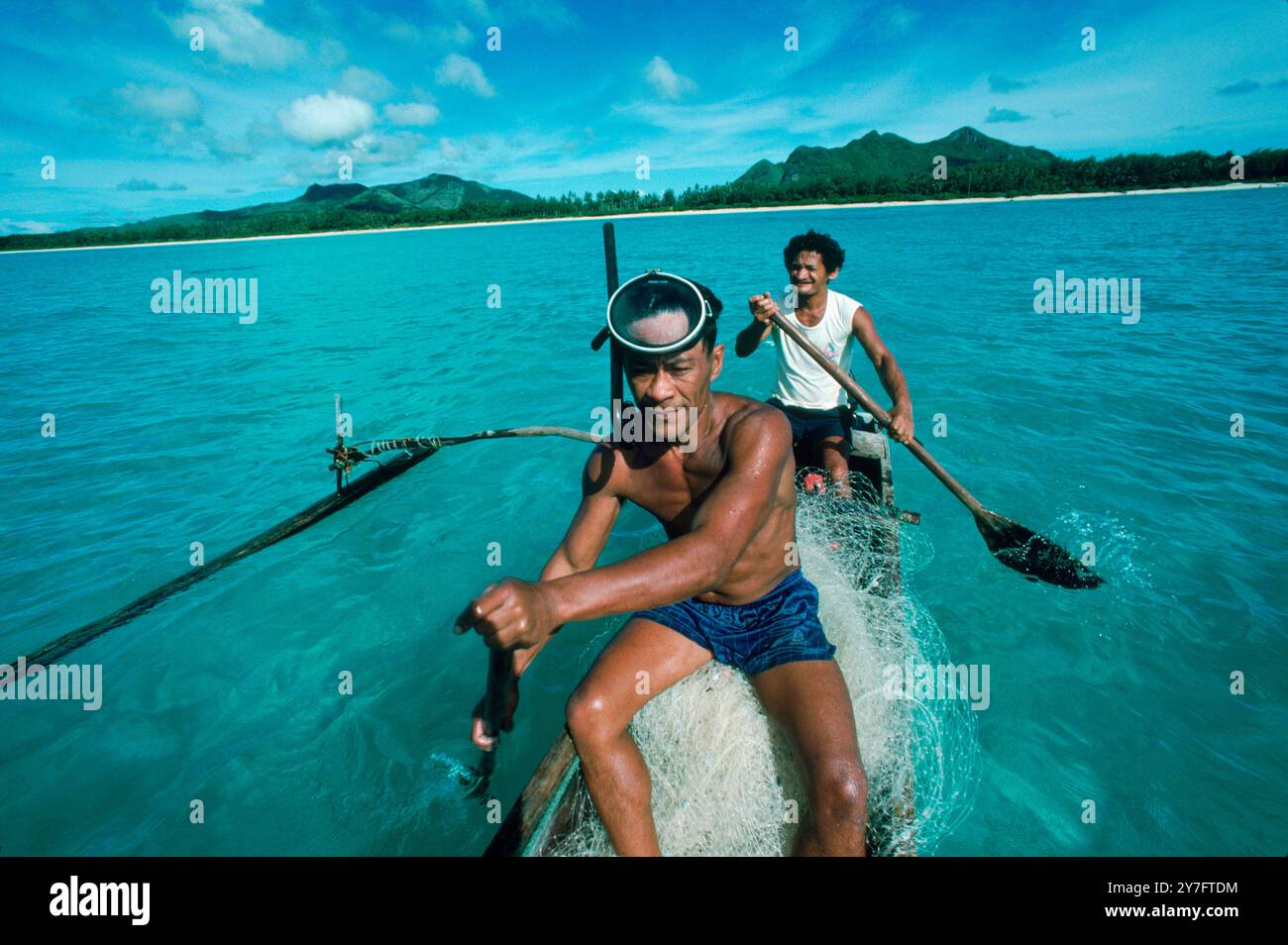 Polynesian men paddle an outrigger off Tubuai Island, French Polynesia ...
