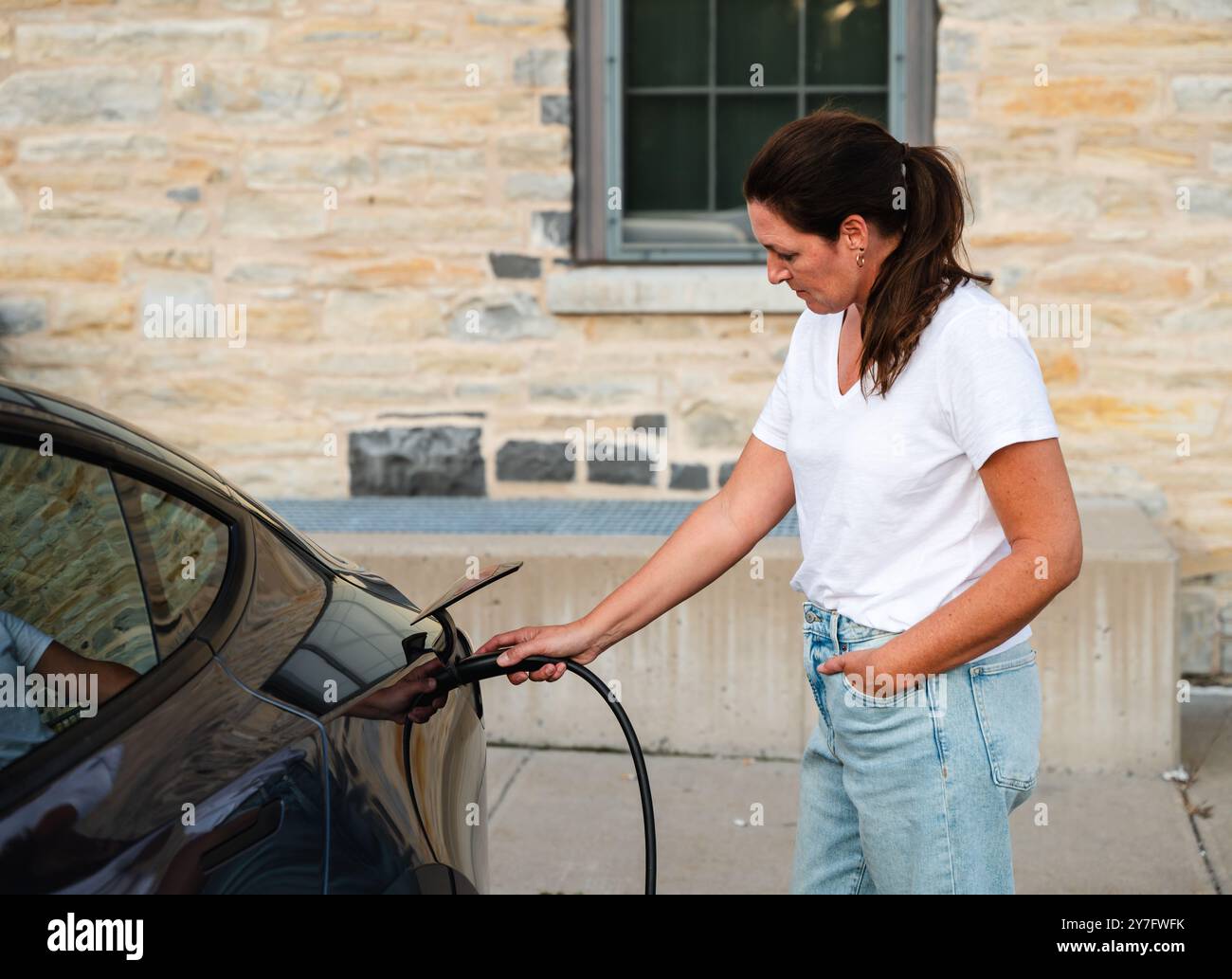 Woman plugging cable car port hi-res stock photography and images - Alamy