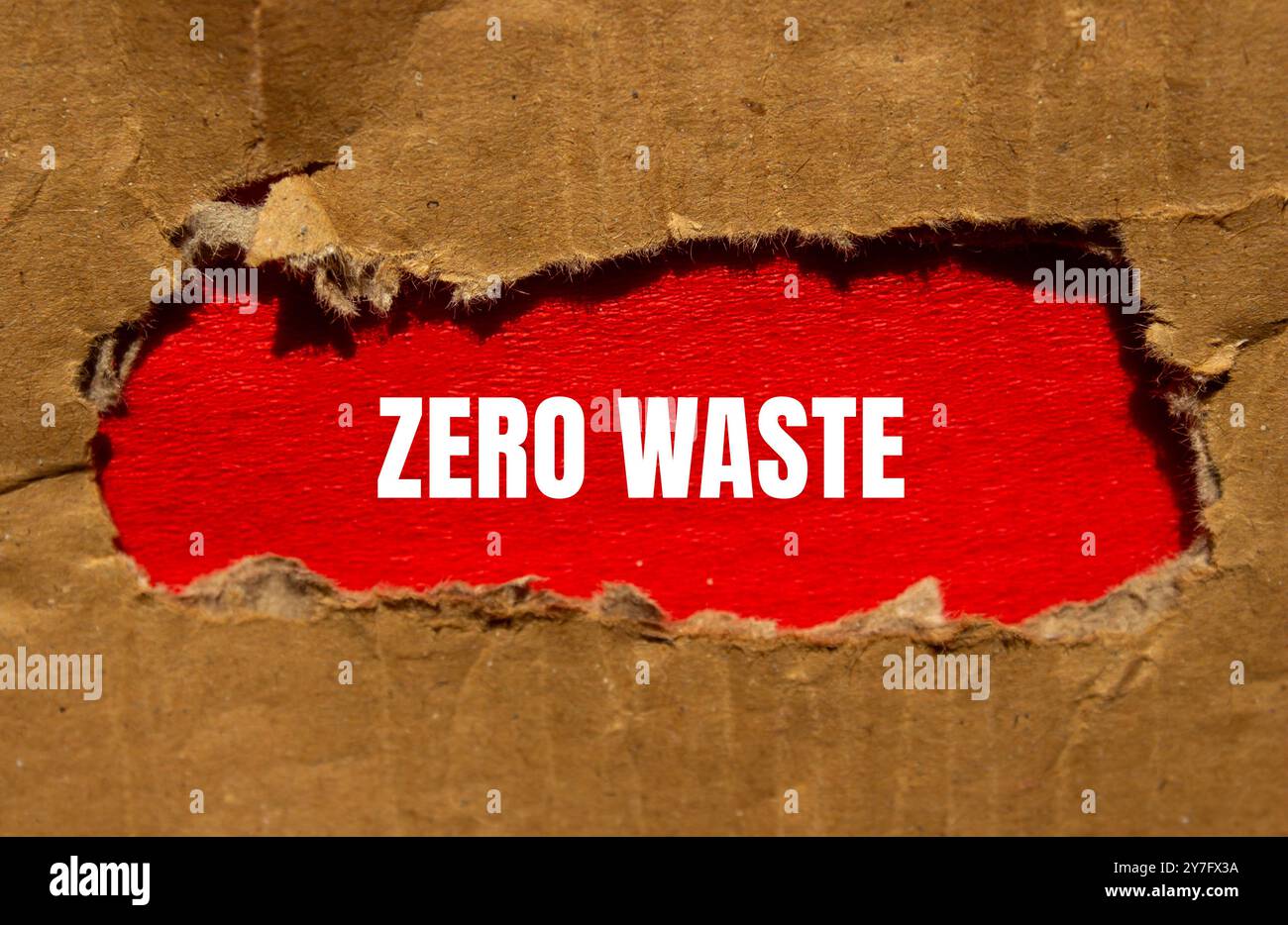 Zero waste message written on torn cardboard paper with red background. Conceptual zero waste ...